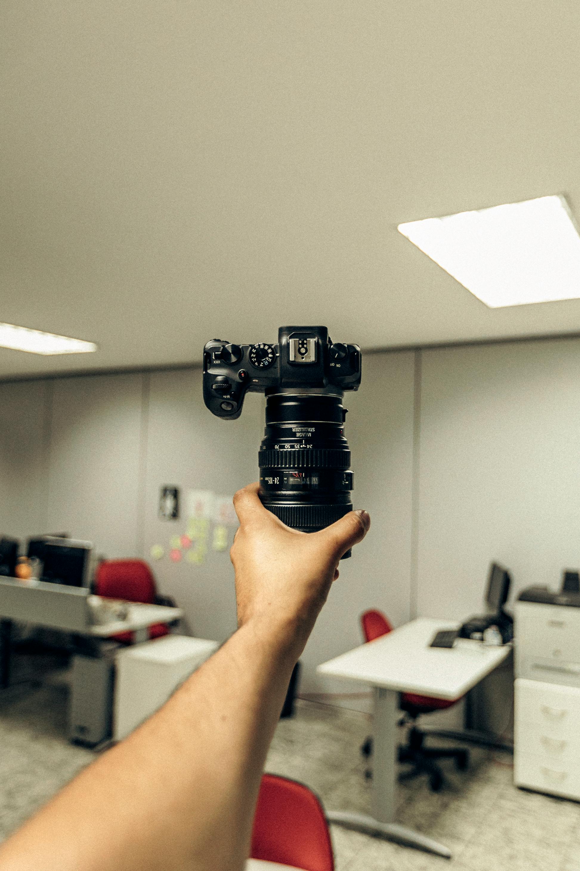 Man Arm Holding Camera in Office · Free Stock Photo