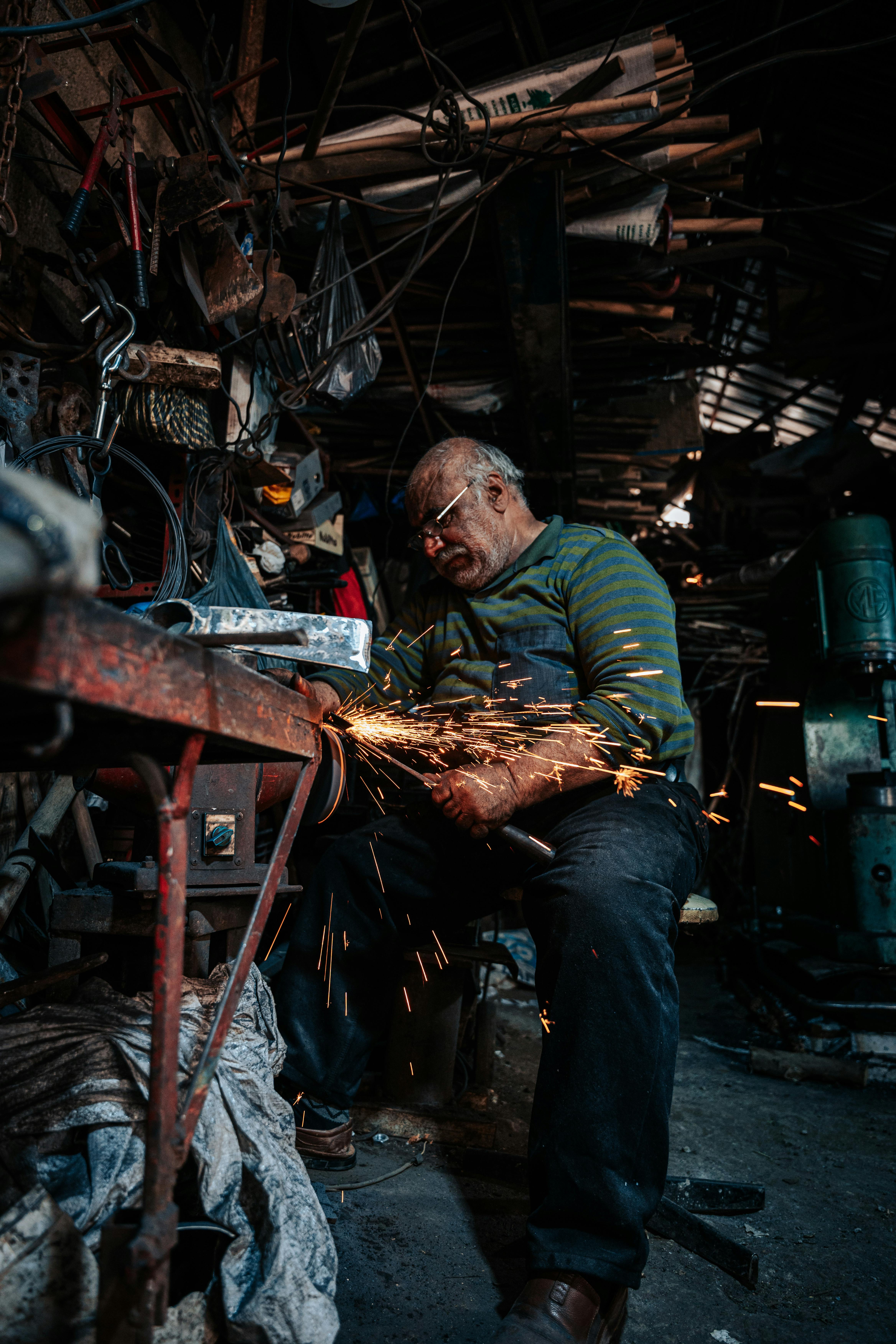Man Using a Grinder in a Workshop · Free Stock Photo
