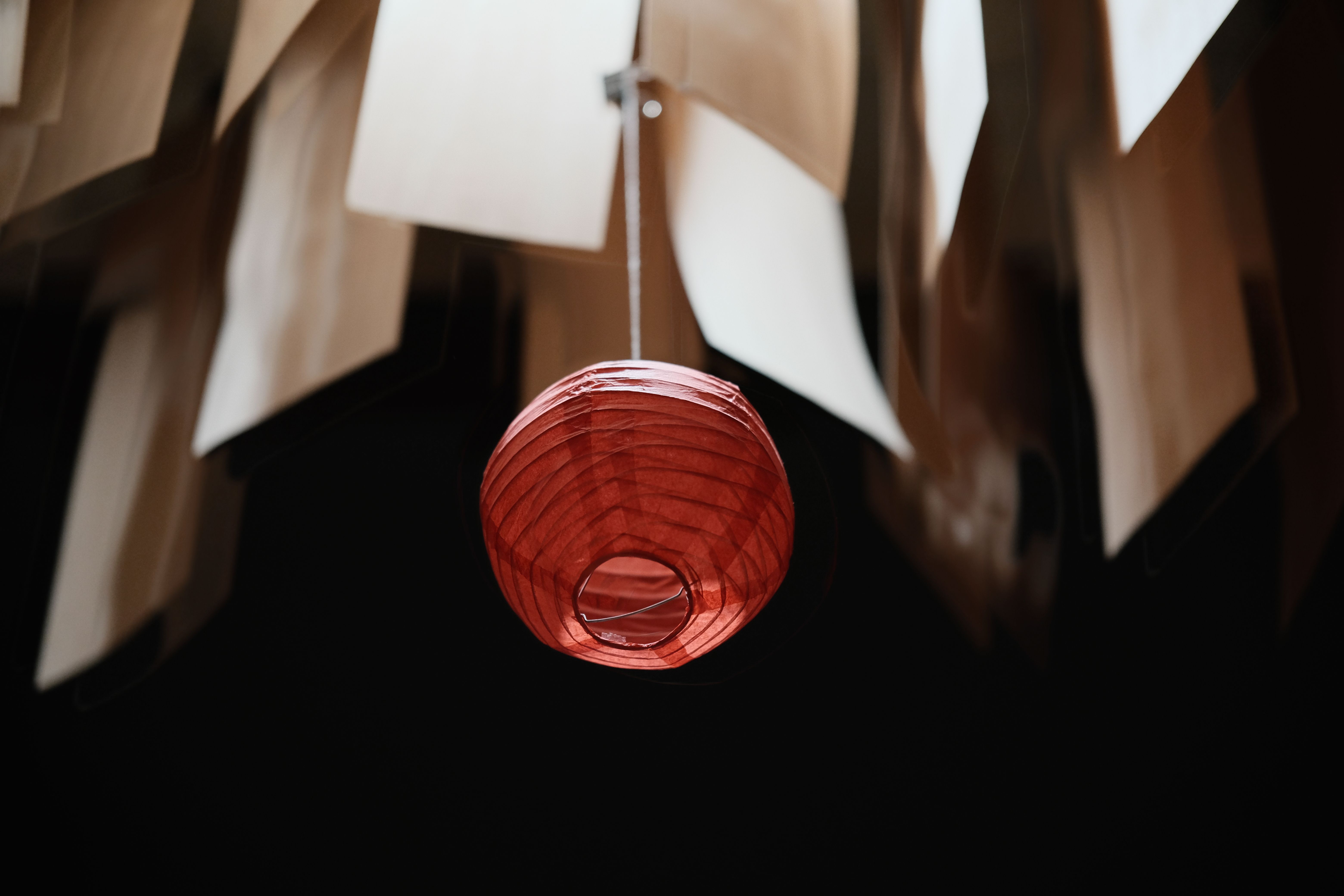 Red Paper Lamp Hanging from the Ceiling Among the Sheets of Paper ...