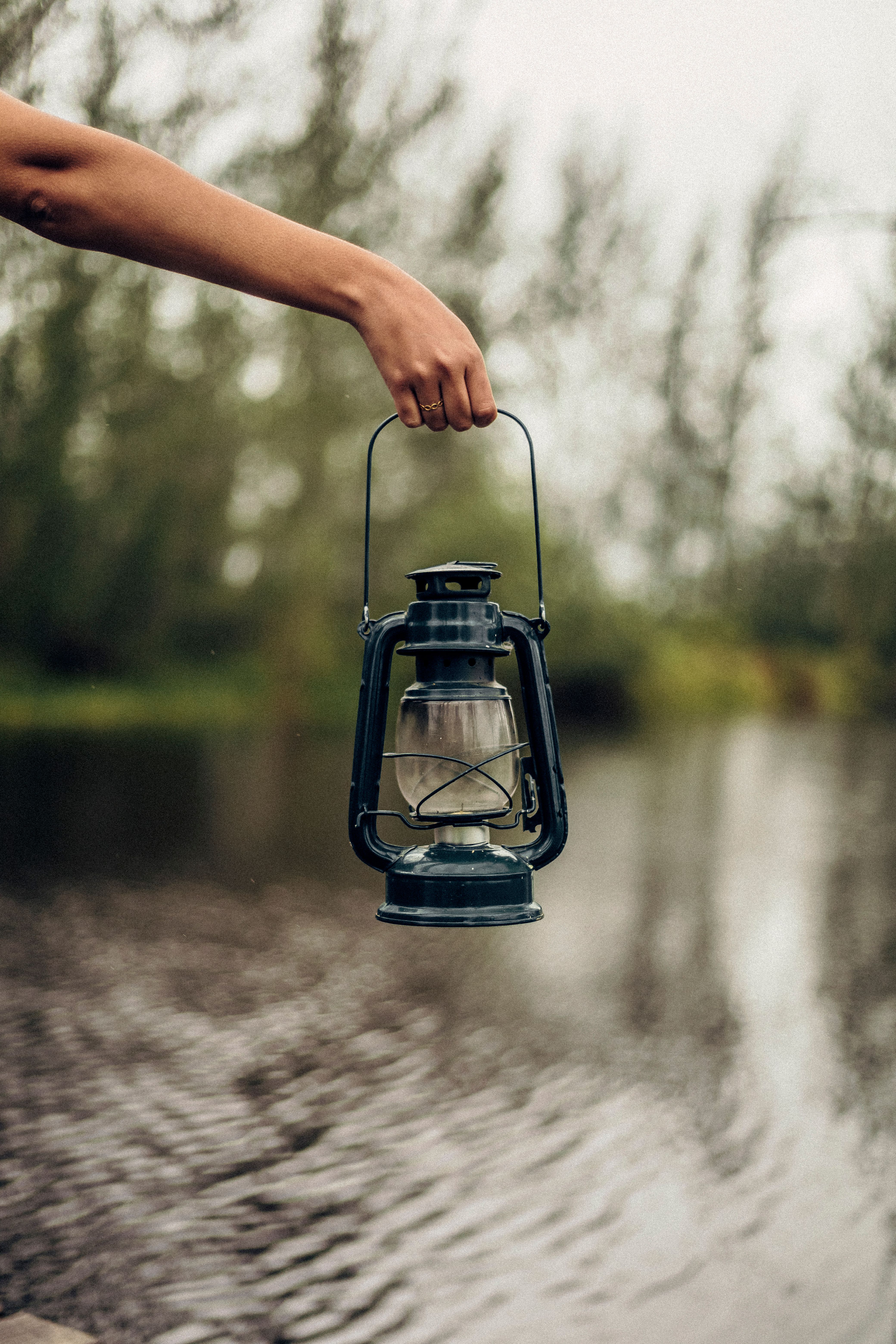 Person Hand Holding Lantern over River · Free Stock Photo