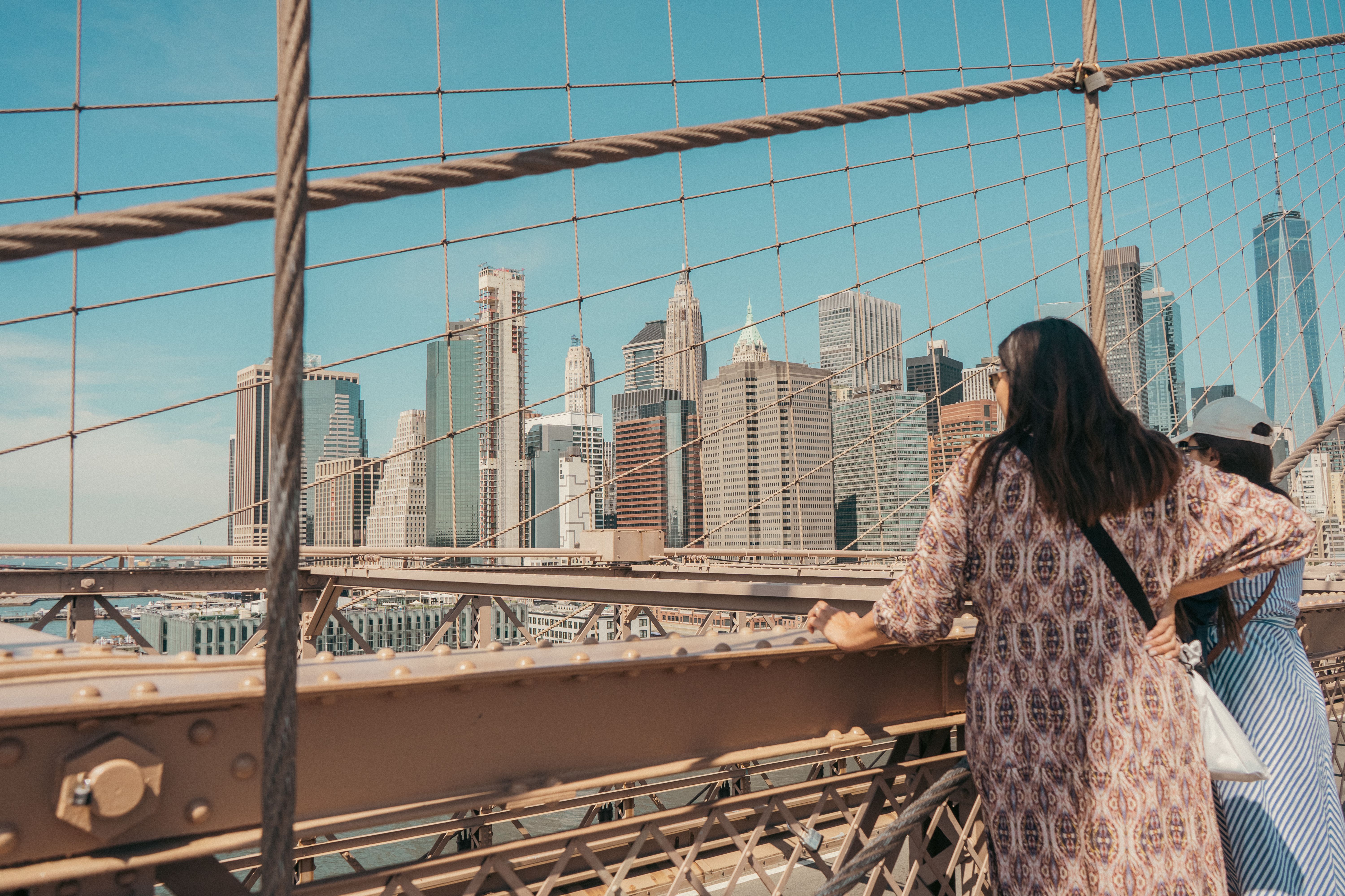 Rear view of Two Women Standing on The Bridge And Looking at Manhattan ...