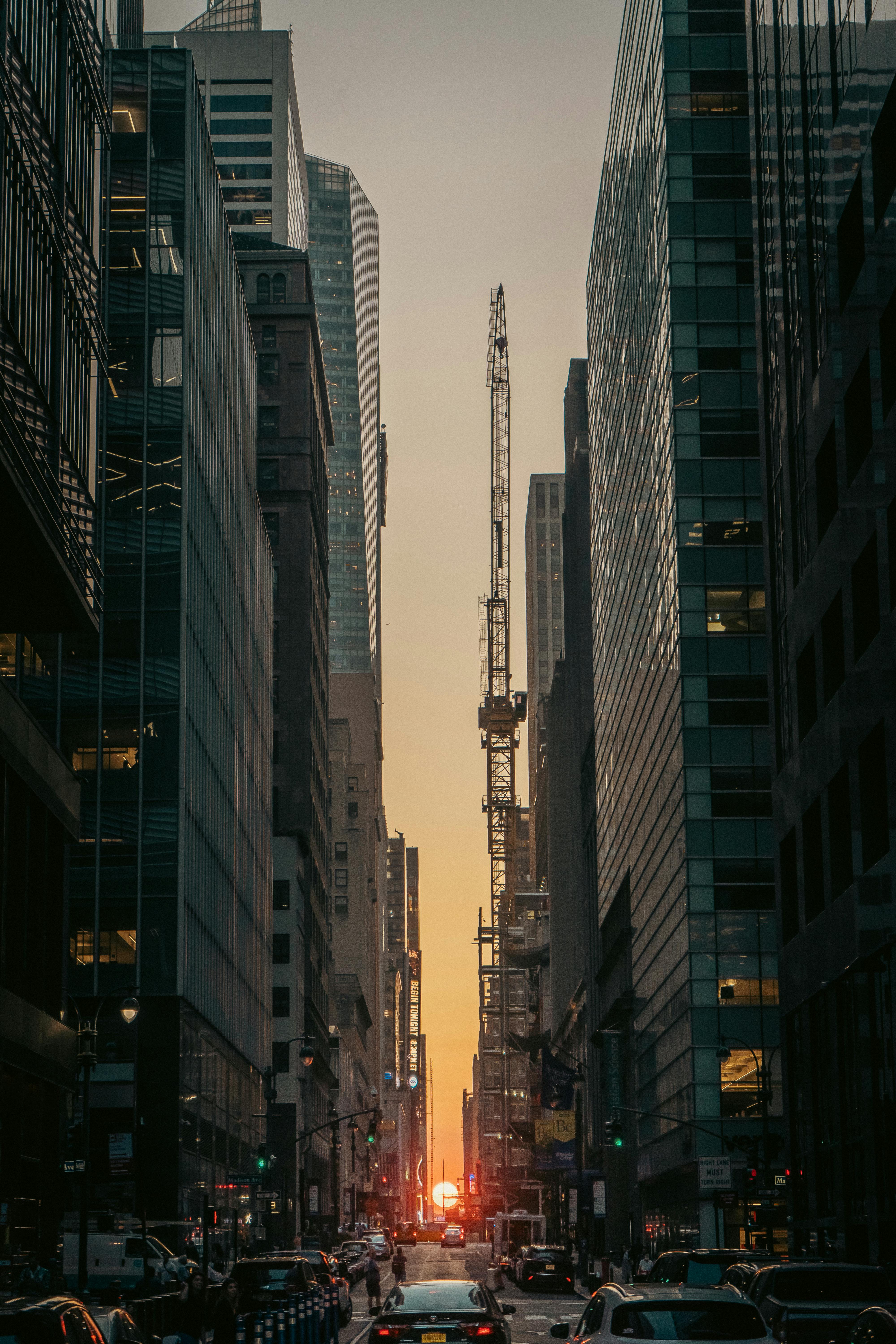Vehicles Passing on Road Between High-rise Building · Free Stock Photo