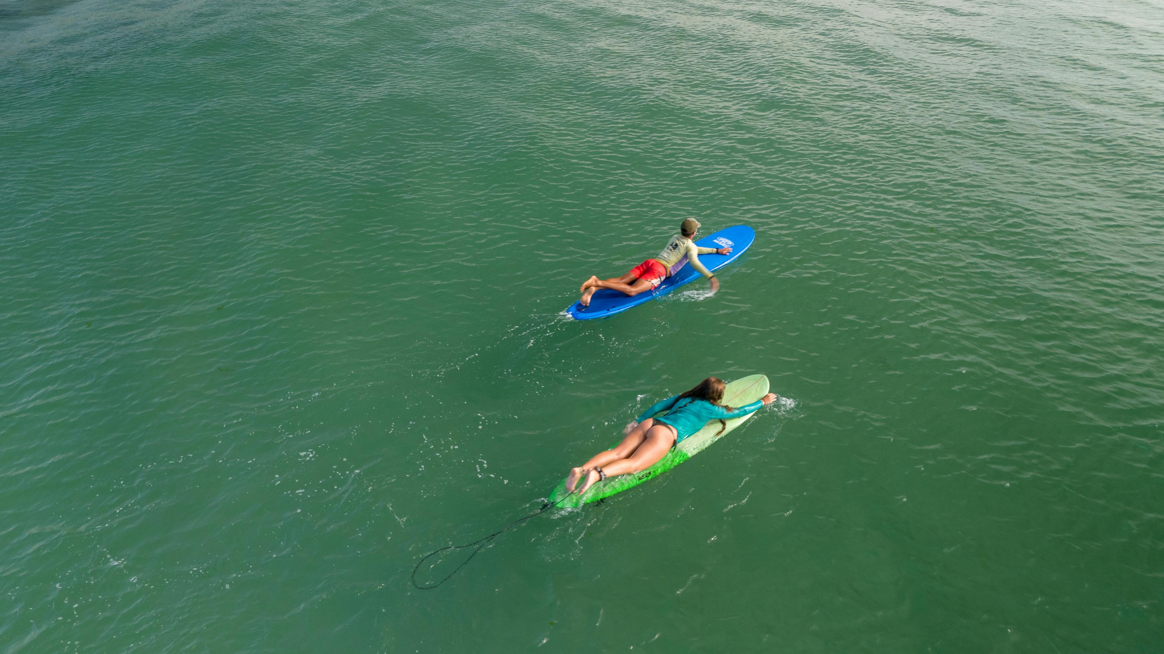 Surfers Paddling Lying on Their Boards · Free Stock Photo