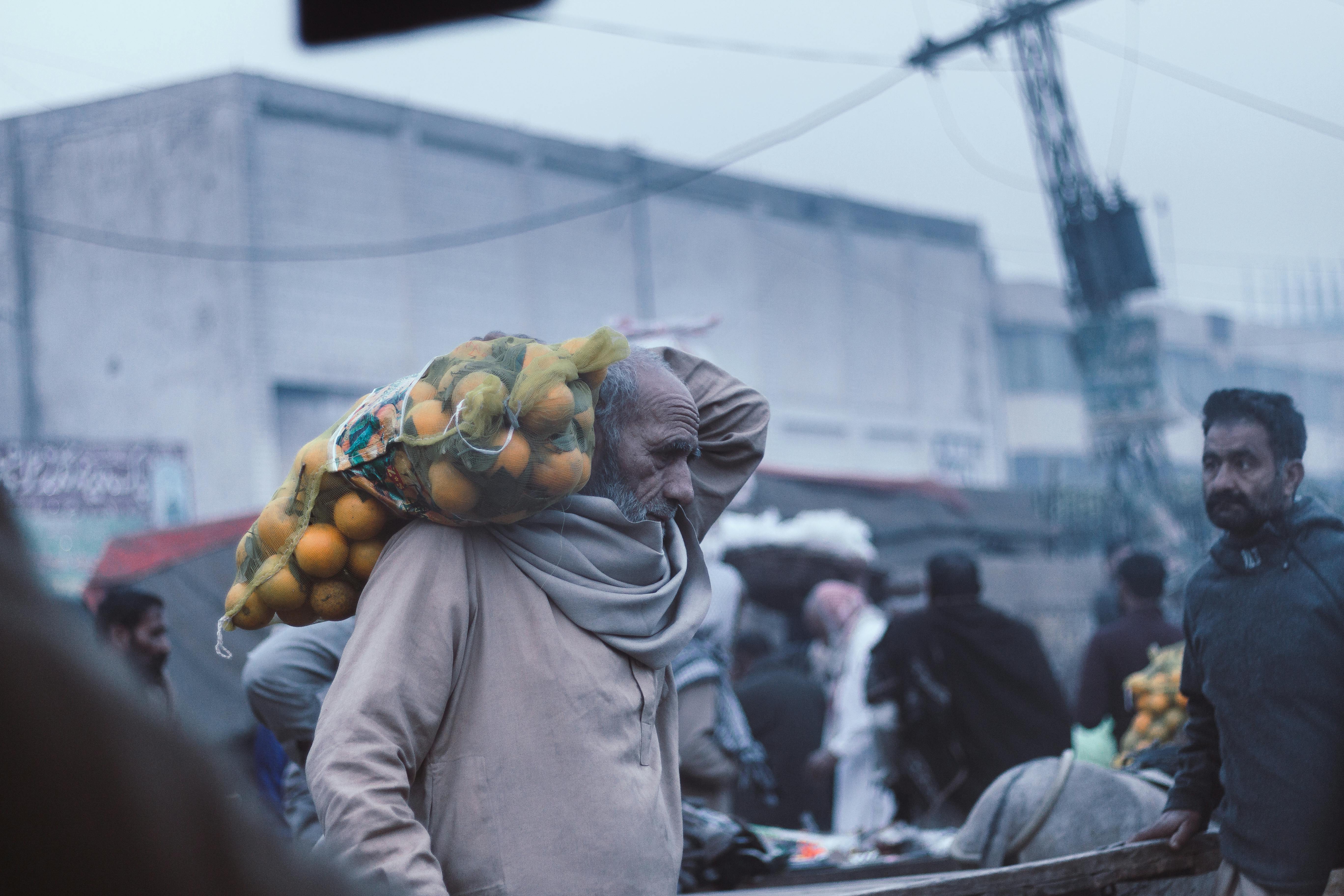 Standing Man Holding Plastic Pail Inside Building · Free Stock Photo