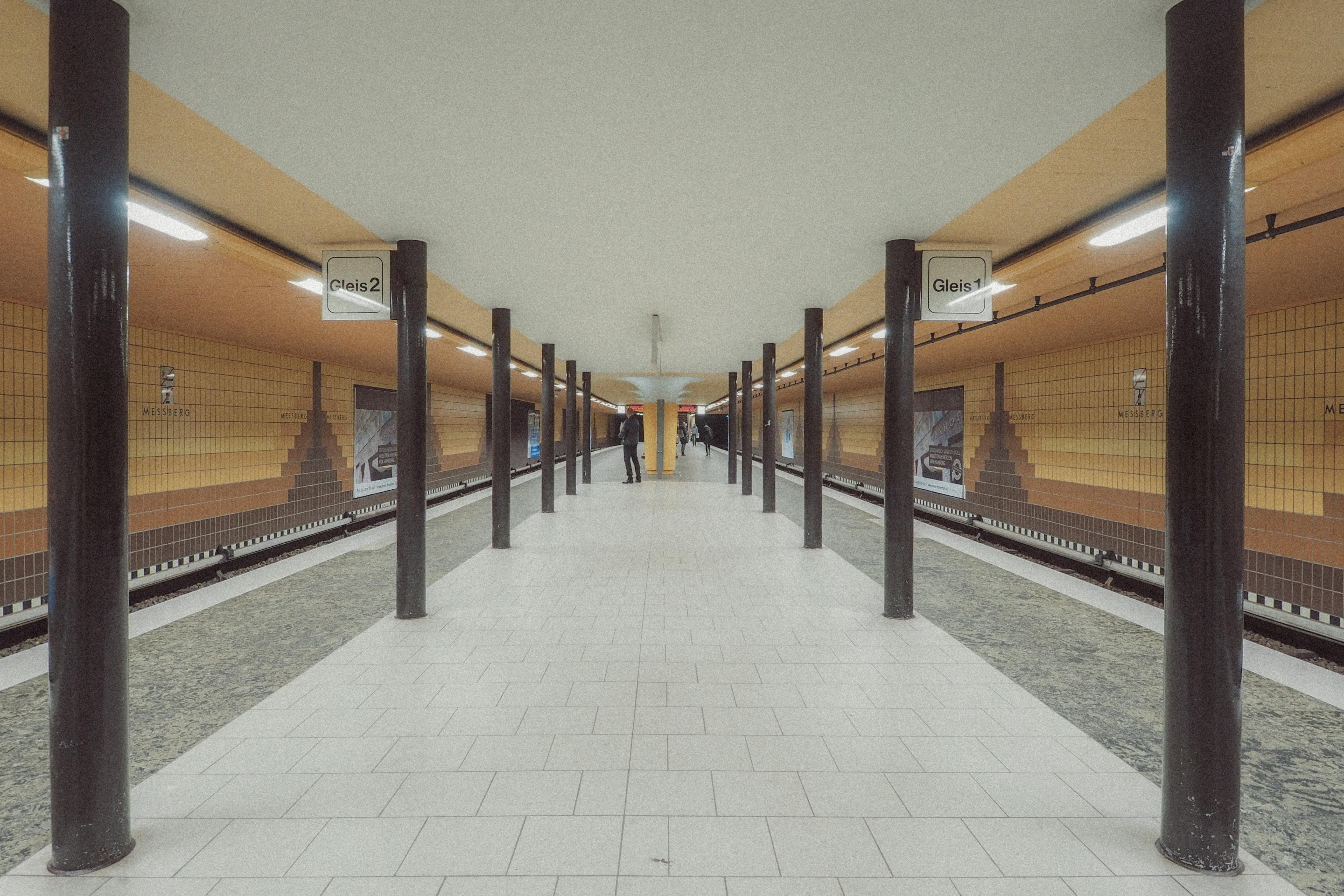 A subway station with a long hallway and a train · Free Stock Photo