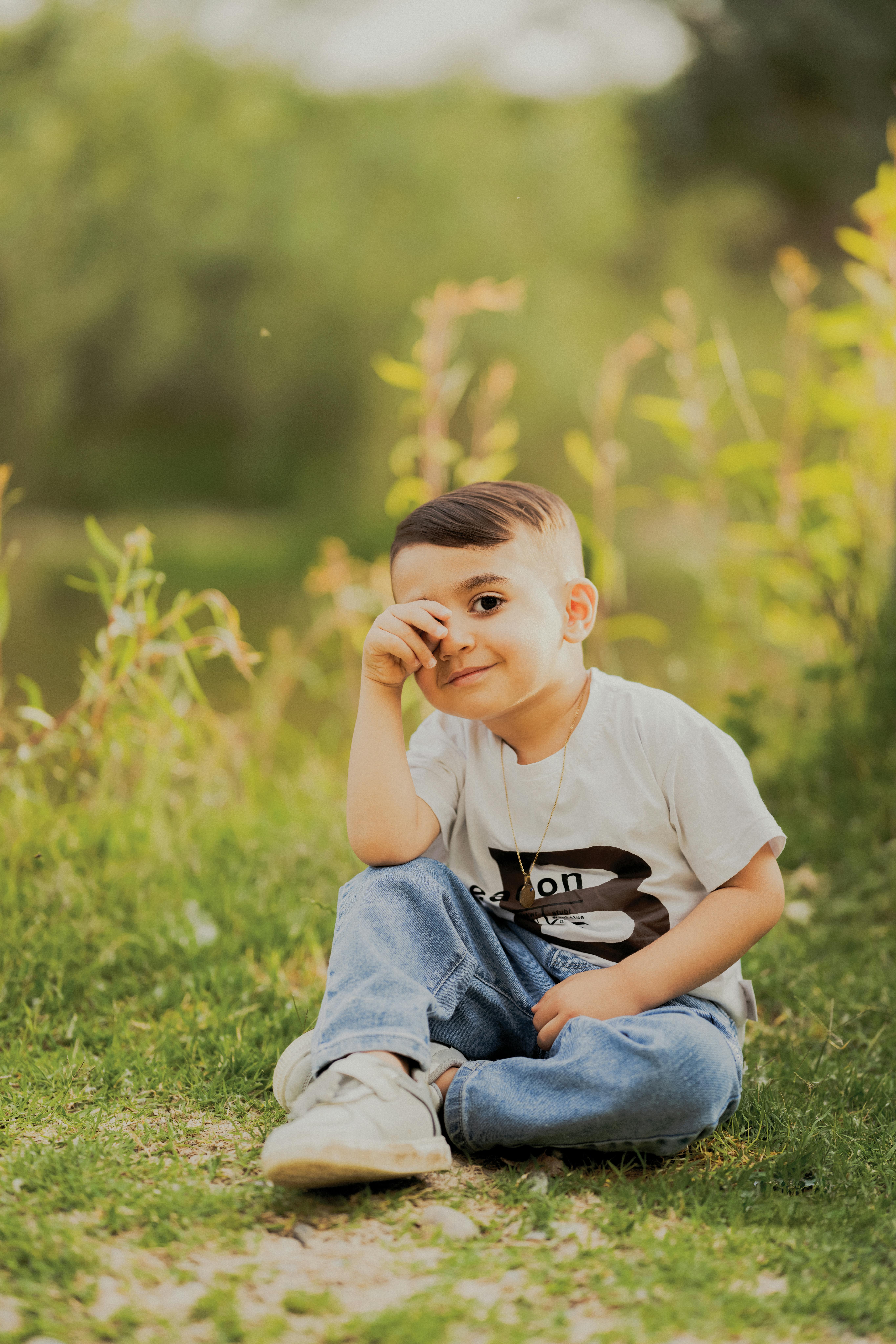 Portrait of a Little Boy Sitting on a Lakeshore · Free Stock Photo