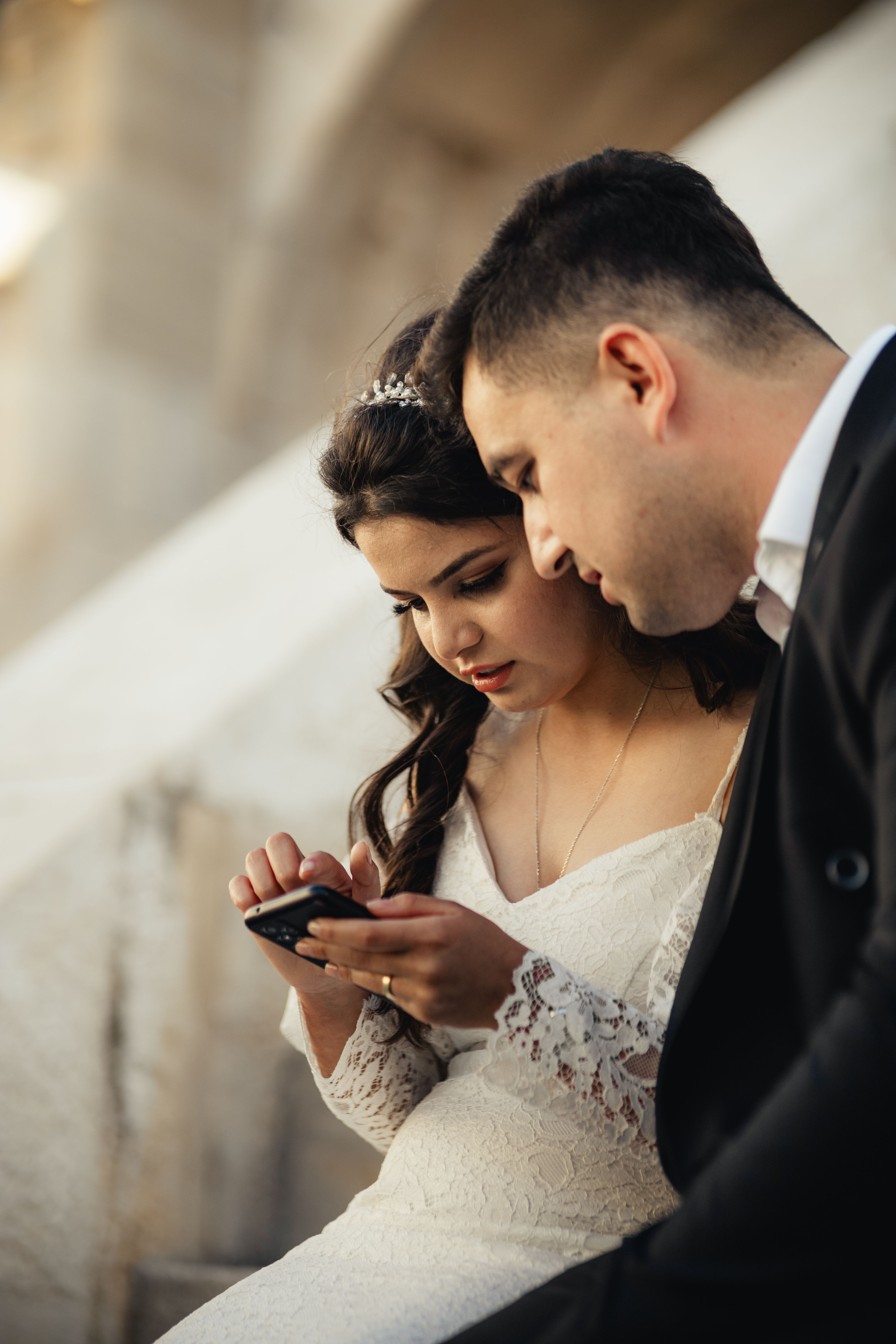 Bride And Groom Looking at a Smart Phone Together · Free Stock Photo