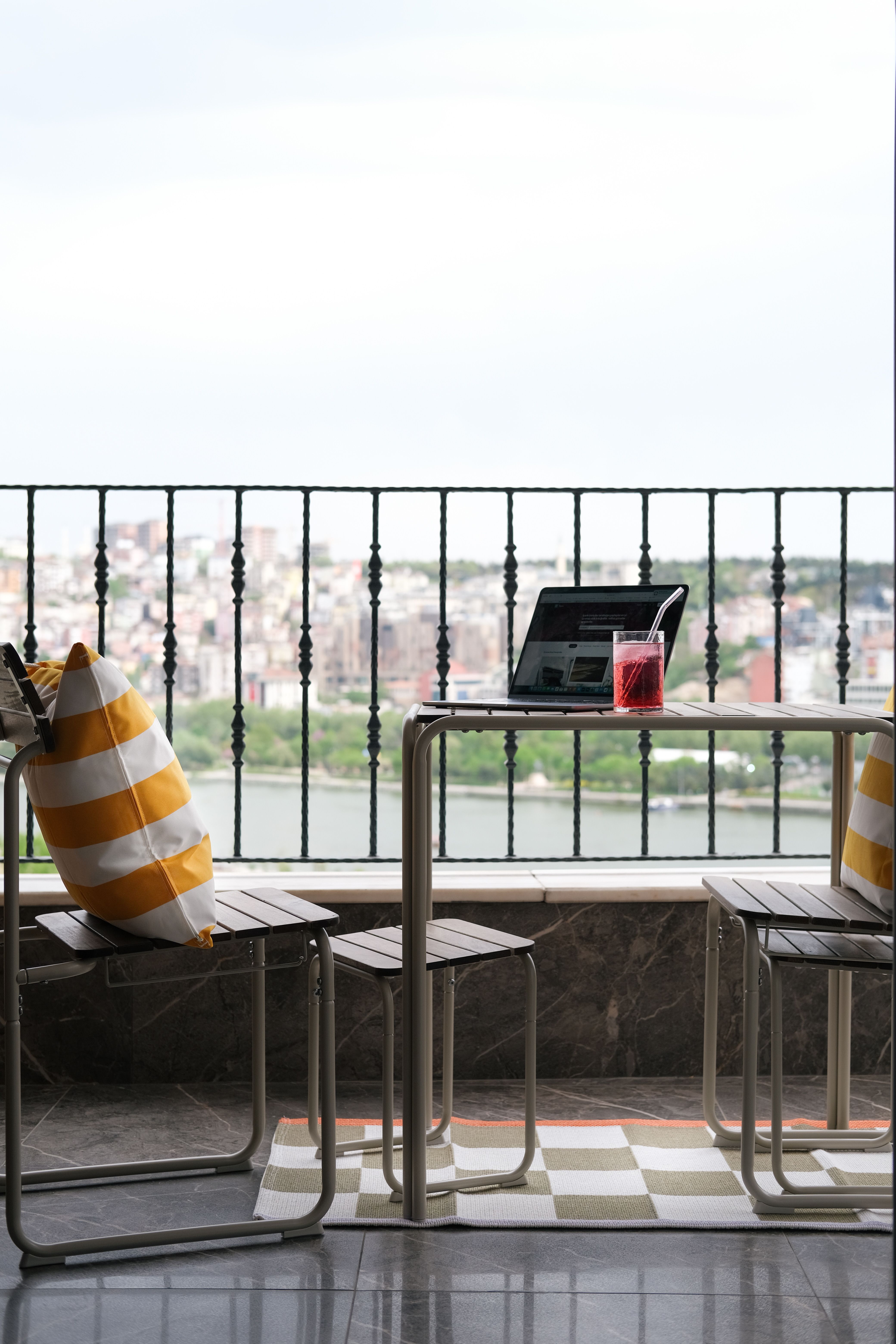 A Laptop and a Drink Standing on a Table on a Balcony · Free Stock Photo