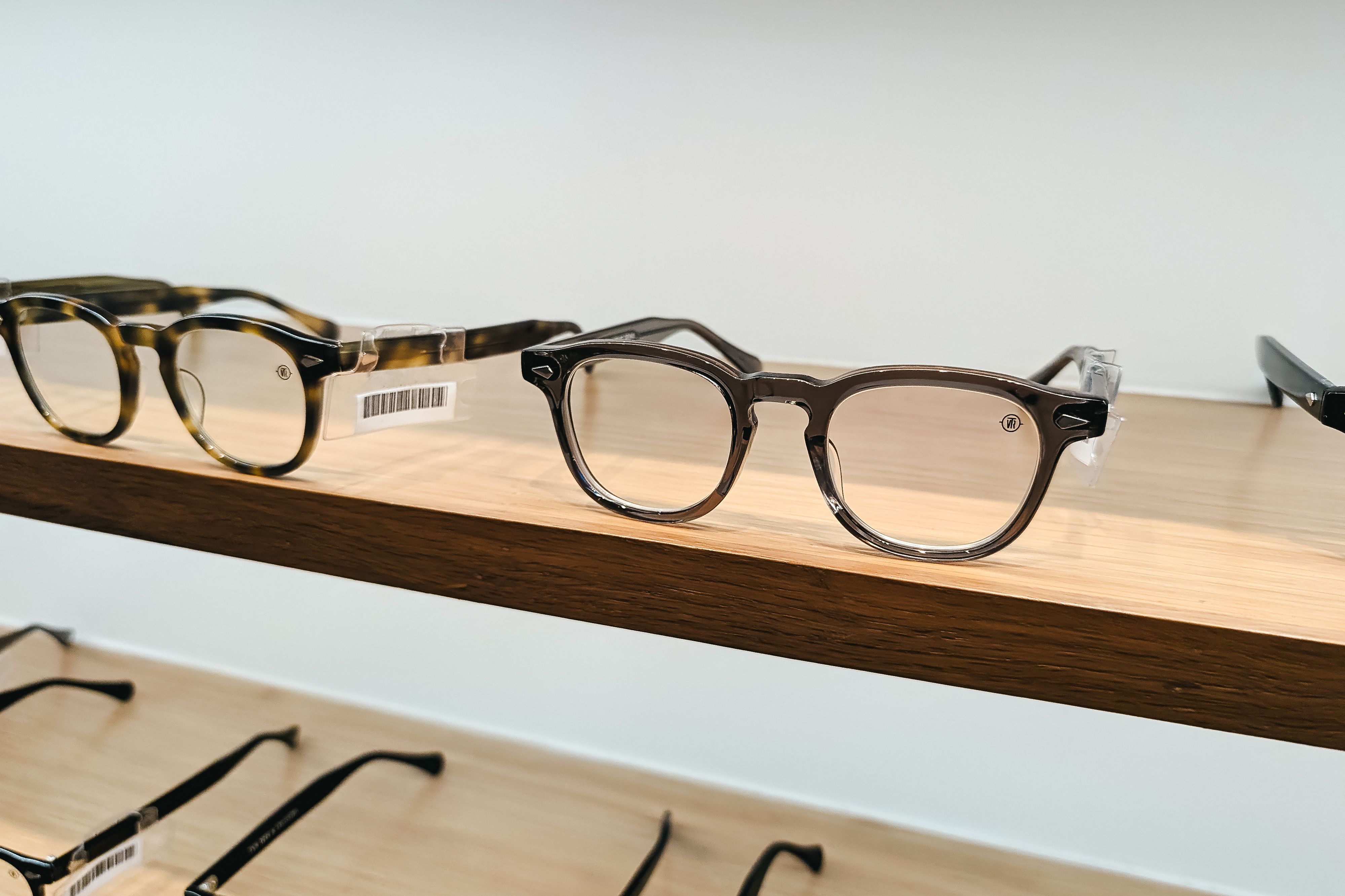A row of glasses on a shelf with a wooden background · Free Stock Photo