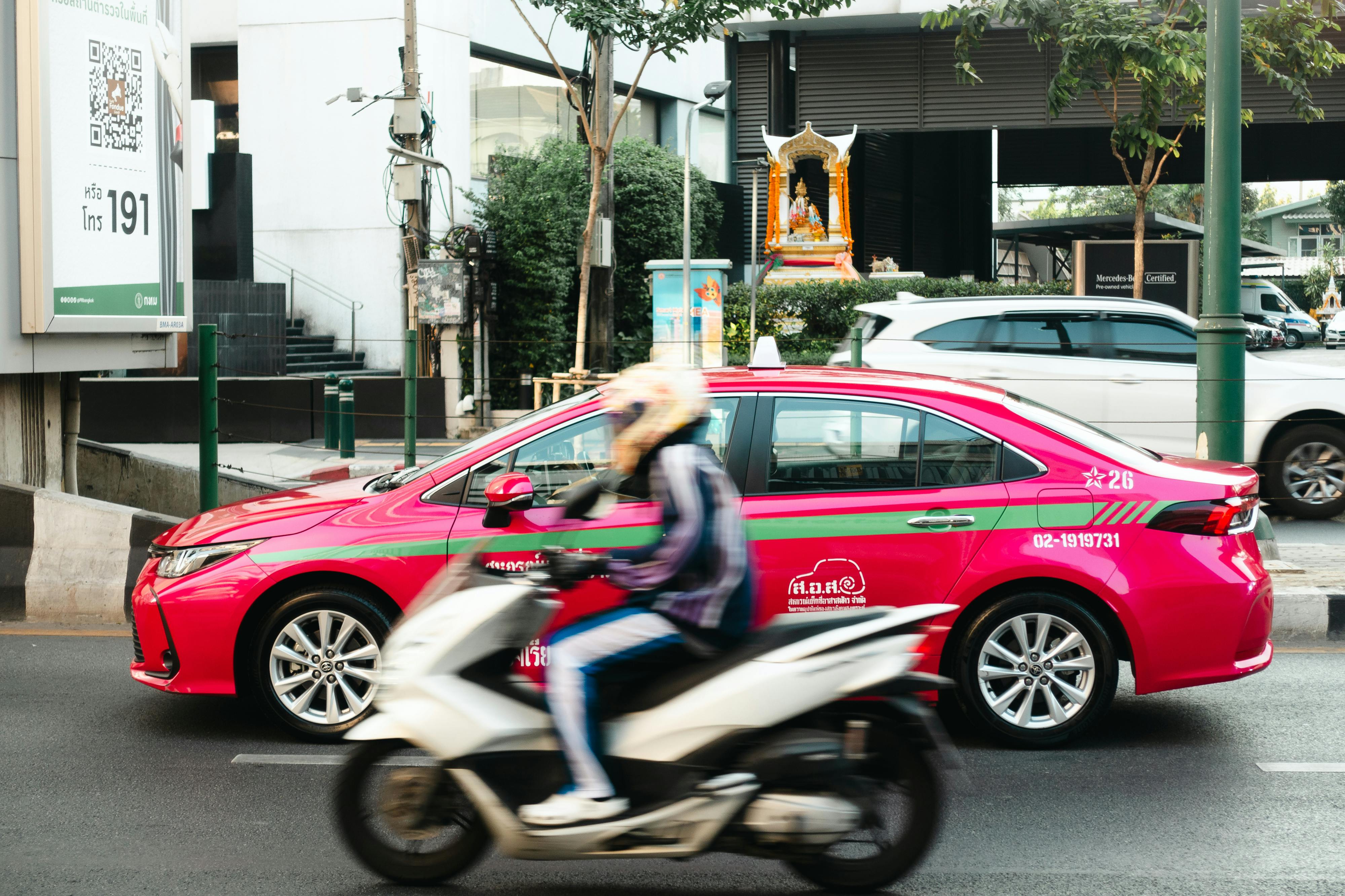 A Man Riding a Motor Scooter on the Street · Free Stock Photo