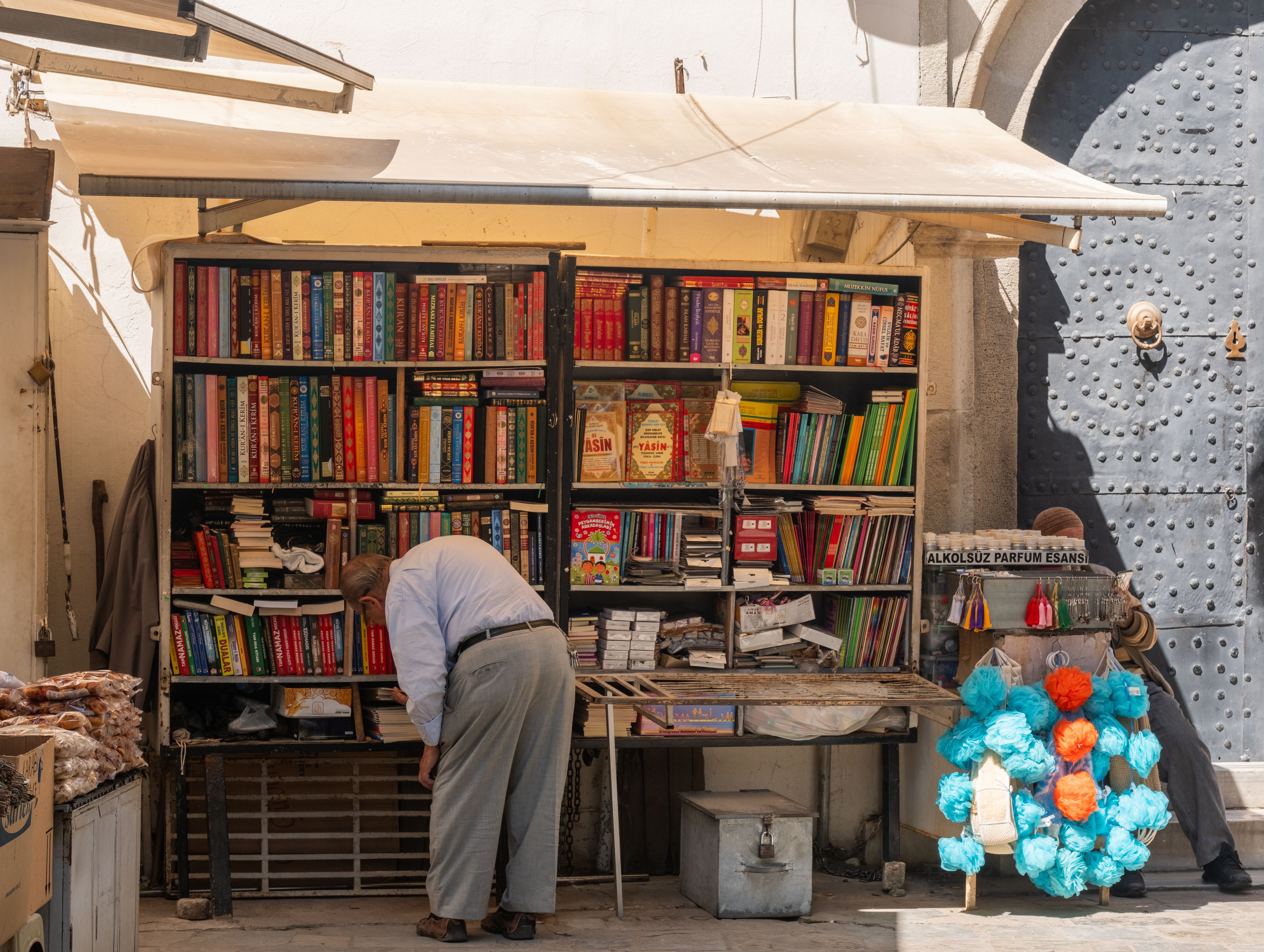 Man Bending in front of Bookshelves · Free Stock Photo