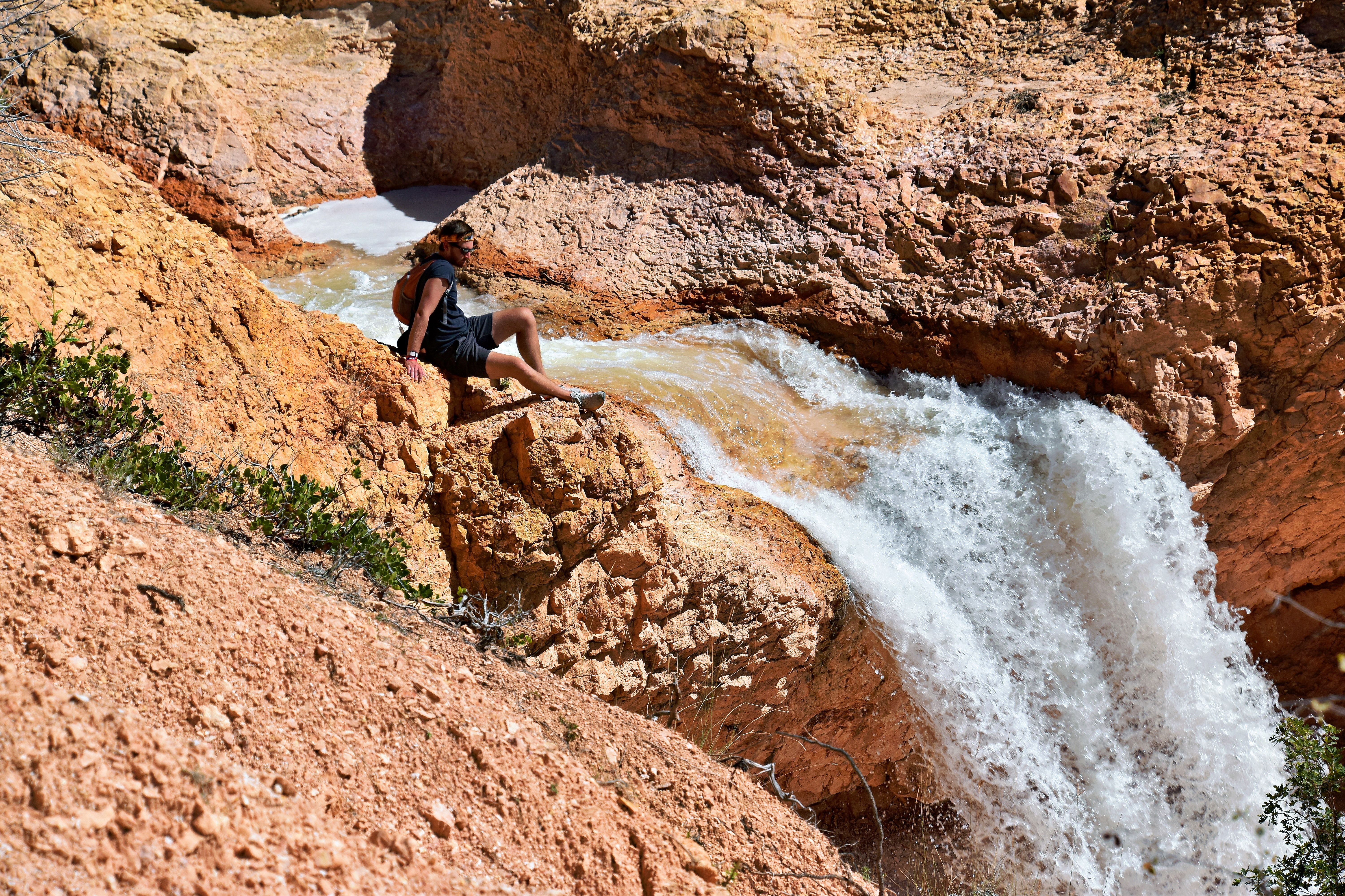 A Man Sitting next to a Cascade · Free Stock Photo