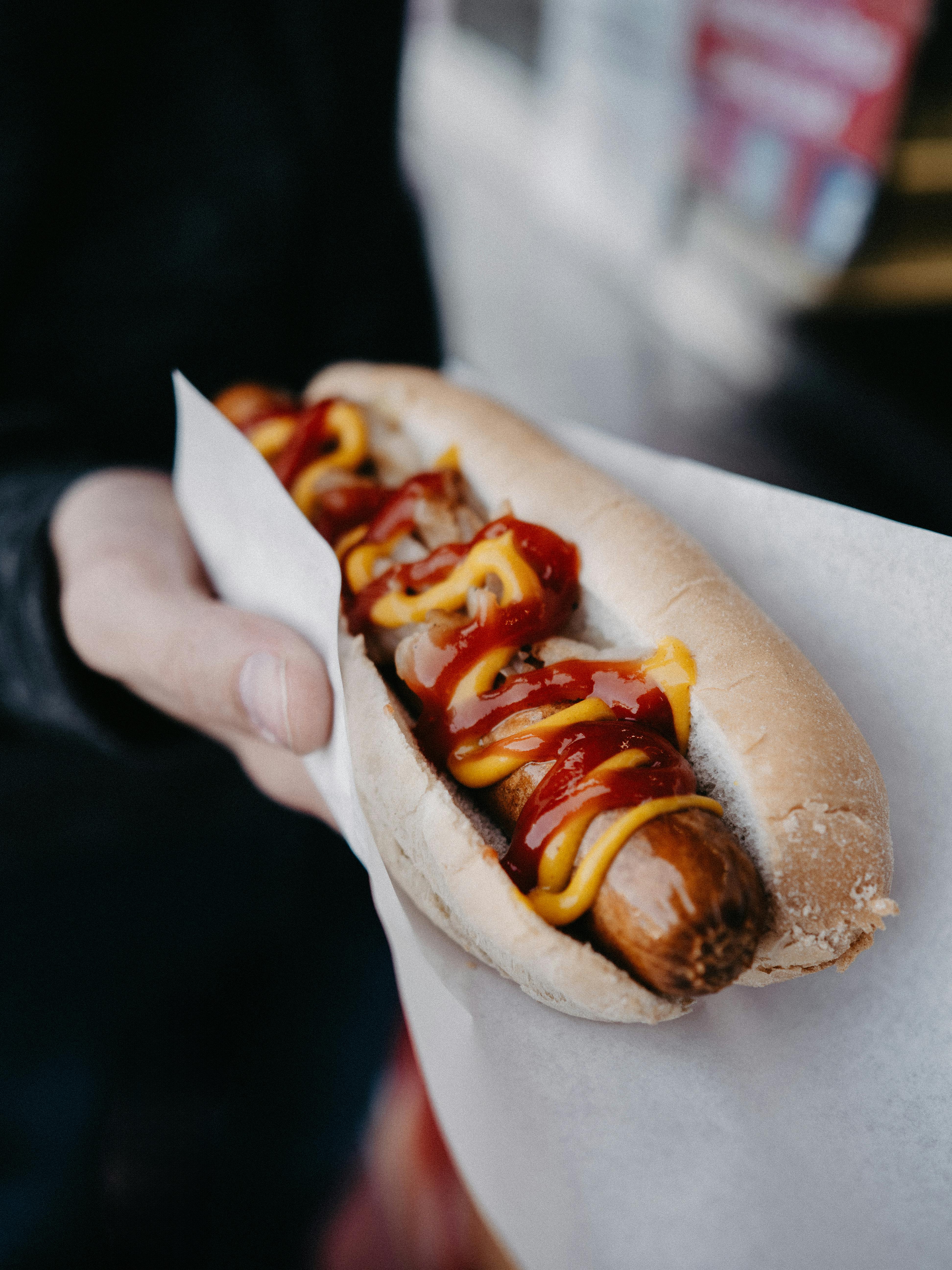 Close-up of a Person Holding a Hot Dog · Free Stock Photo