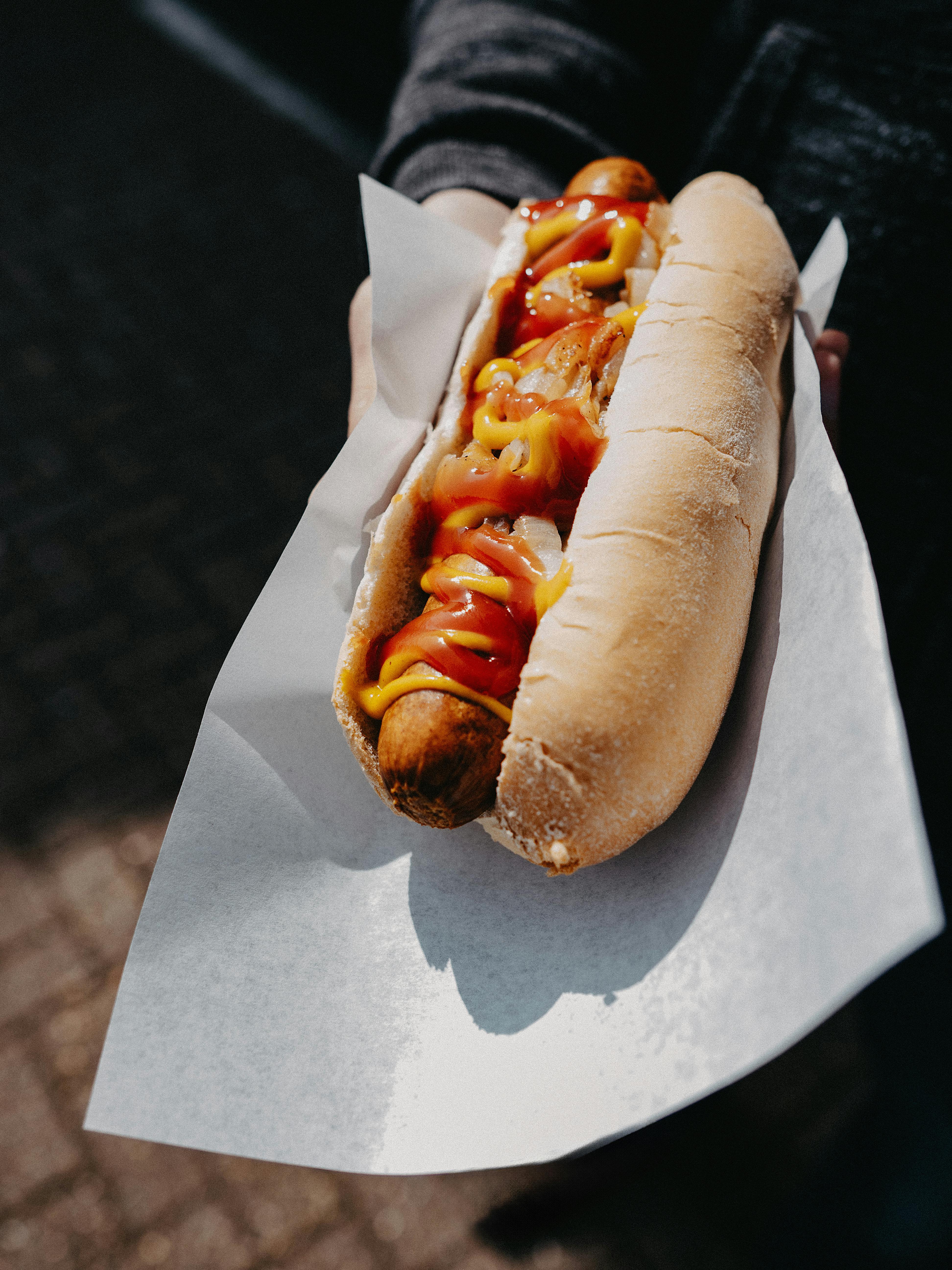 Close-up of a Person Holding a Hot Dog · Free Stock Photo