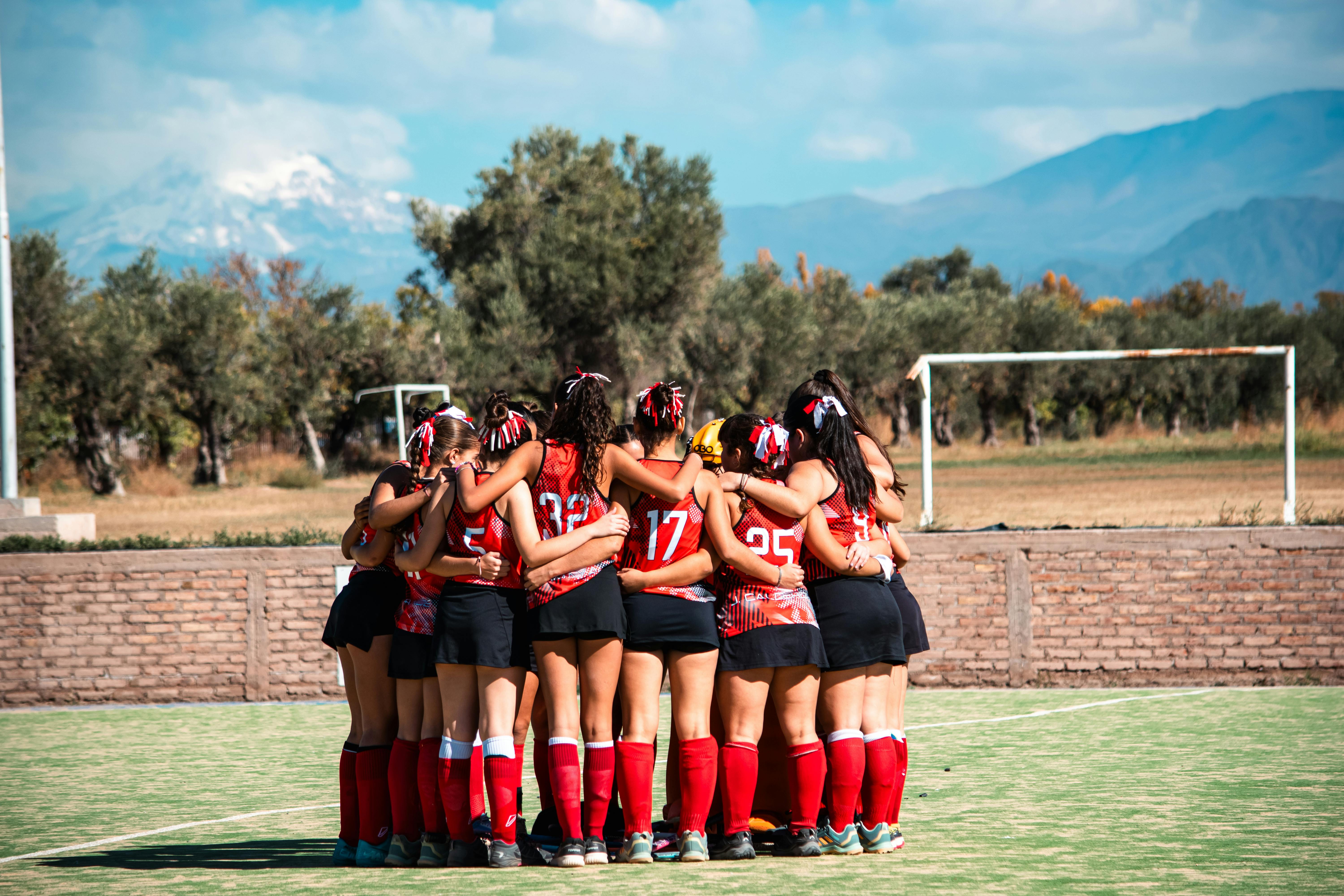 A group of girls huddle together in a circle · Free Stock Photo