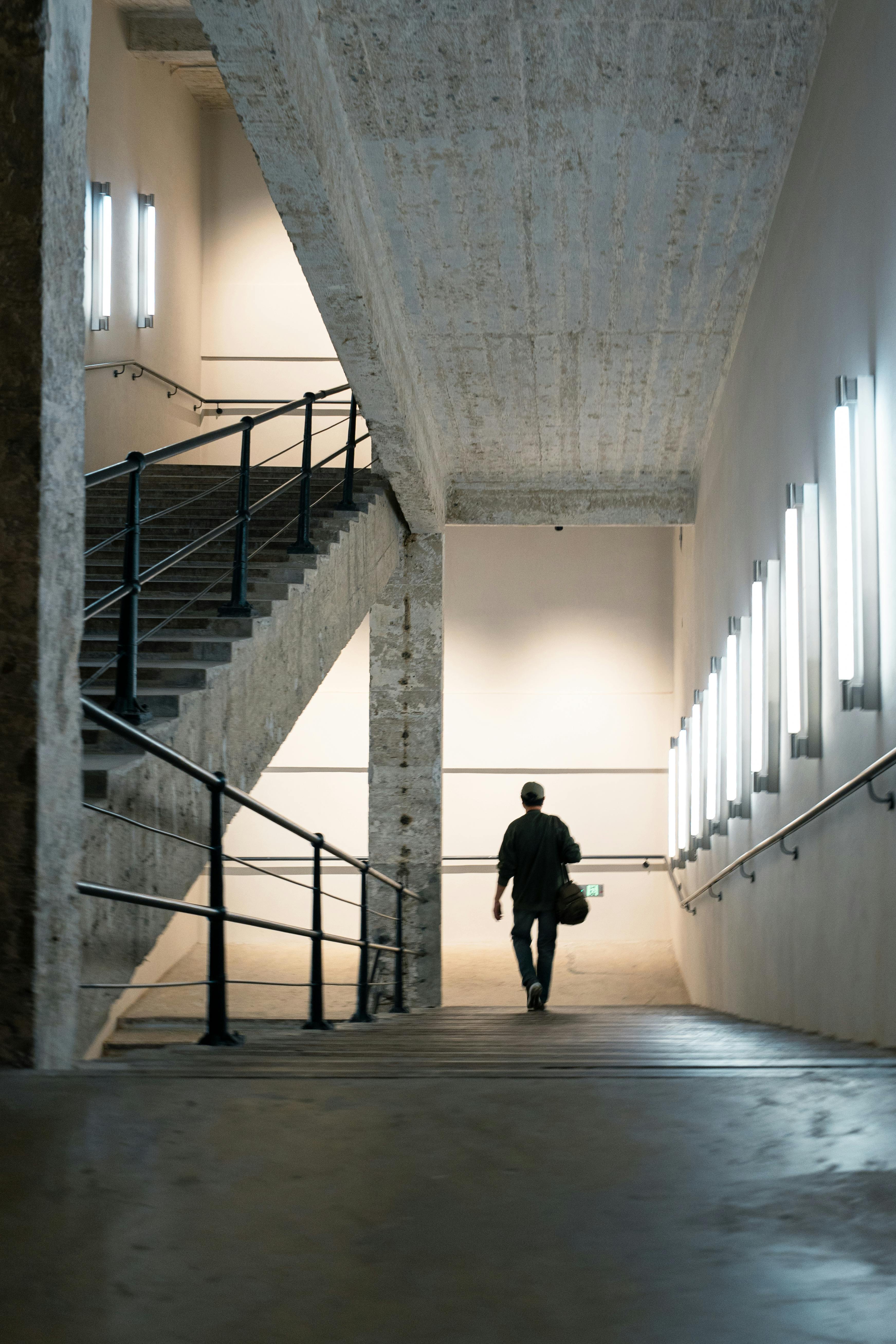 Back View of a Man Walking Down the Stairs in a Building · Free Stock Photo