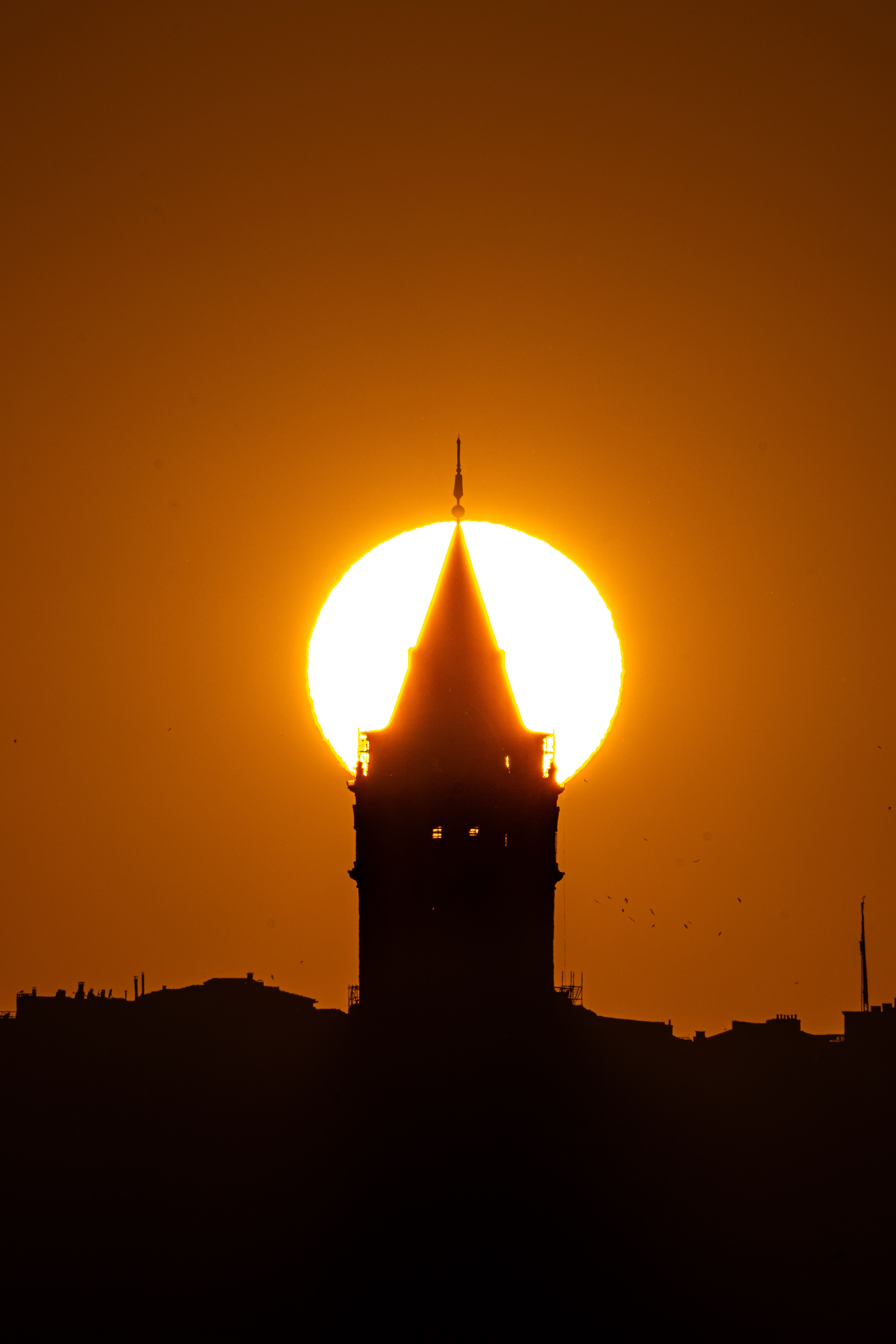 The sun is setting behind a clock tower · Free Stock Photo