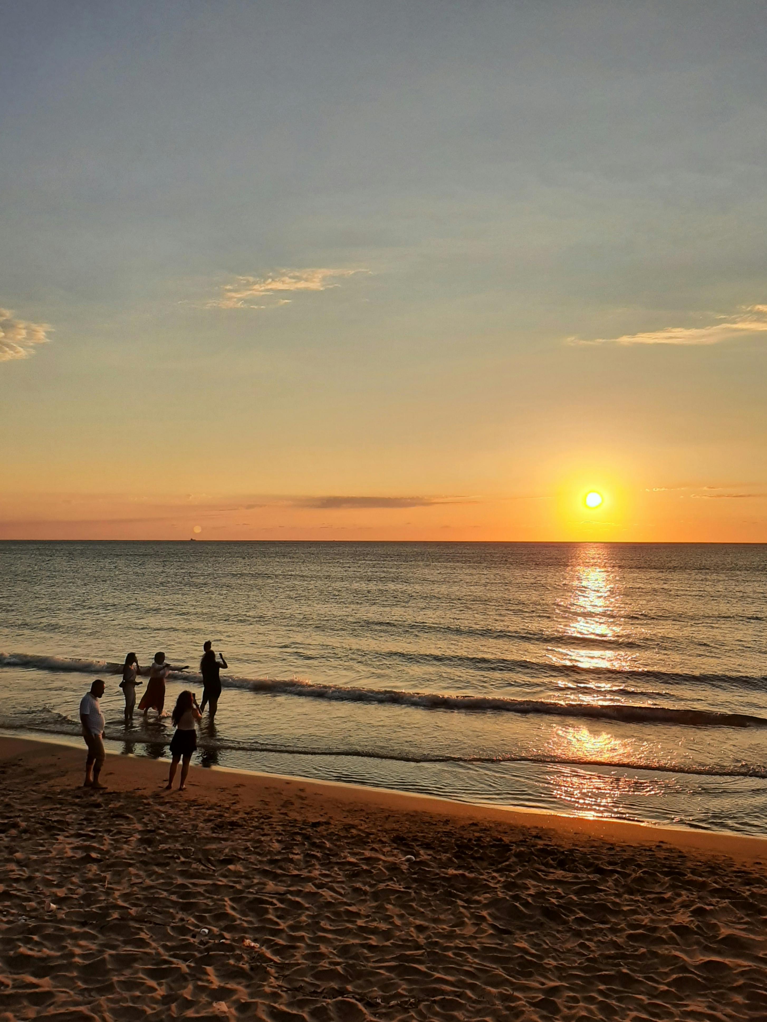 People on Beach Watching Sunset over Sea · Free Stock Photo