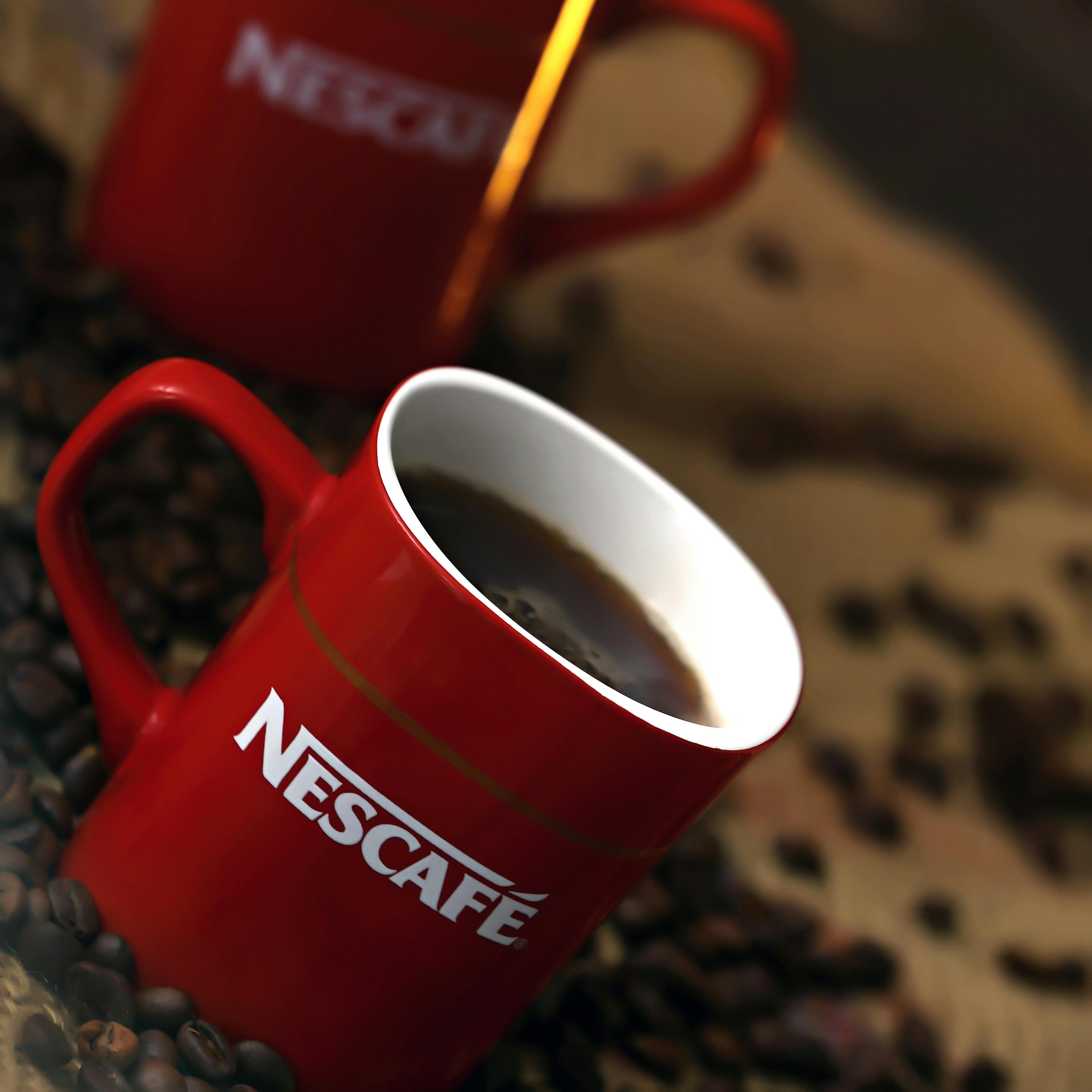 White and Red Nescafe Ceramic Coffee Mug With Coffee · Free Stock Photo