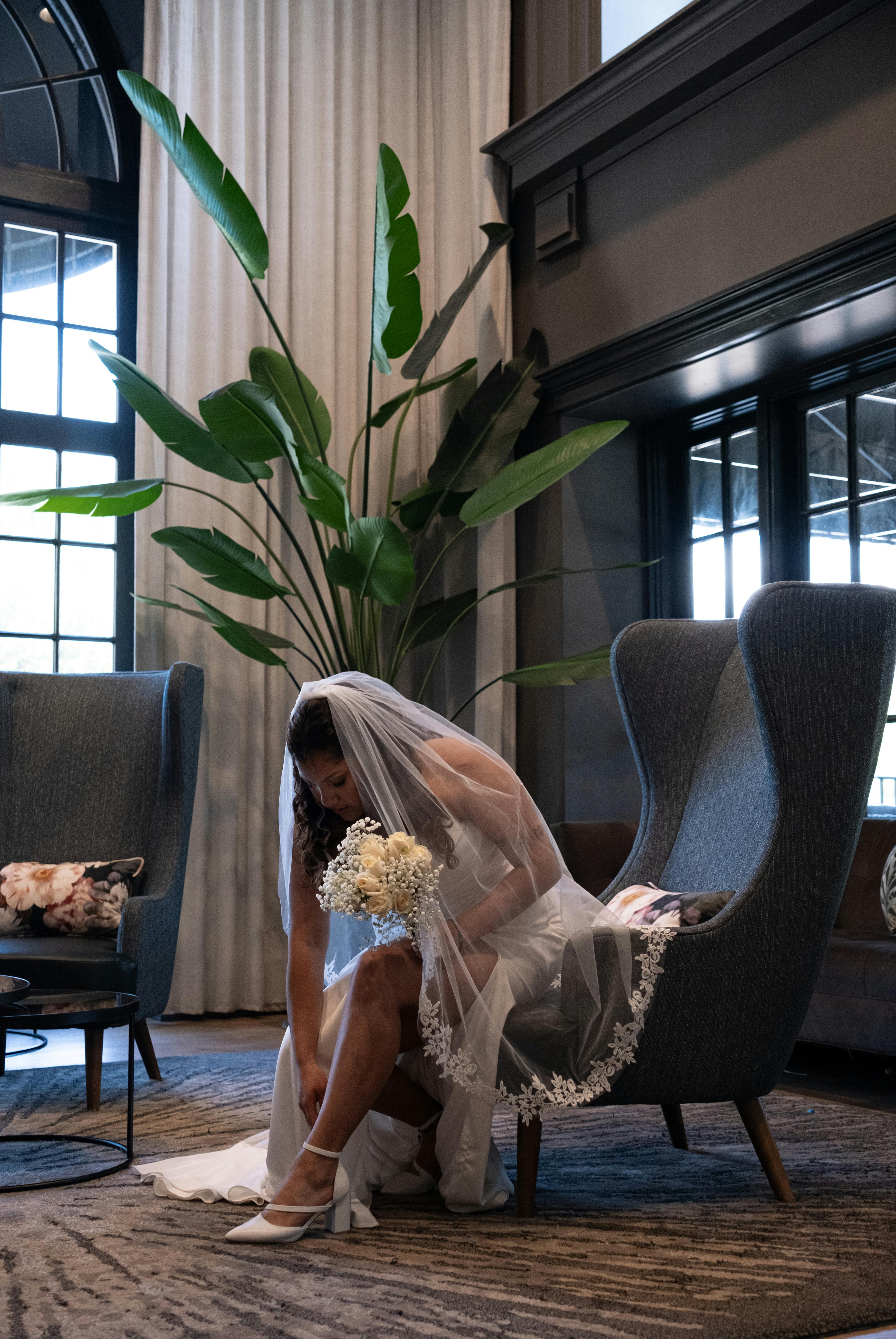 A bride in a wedding dress sitting on a chair · Free Stock Photo