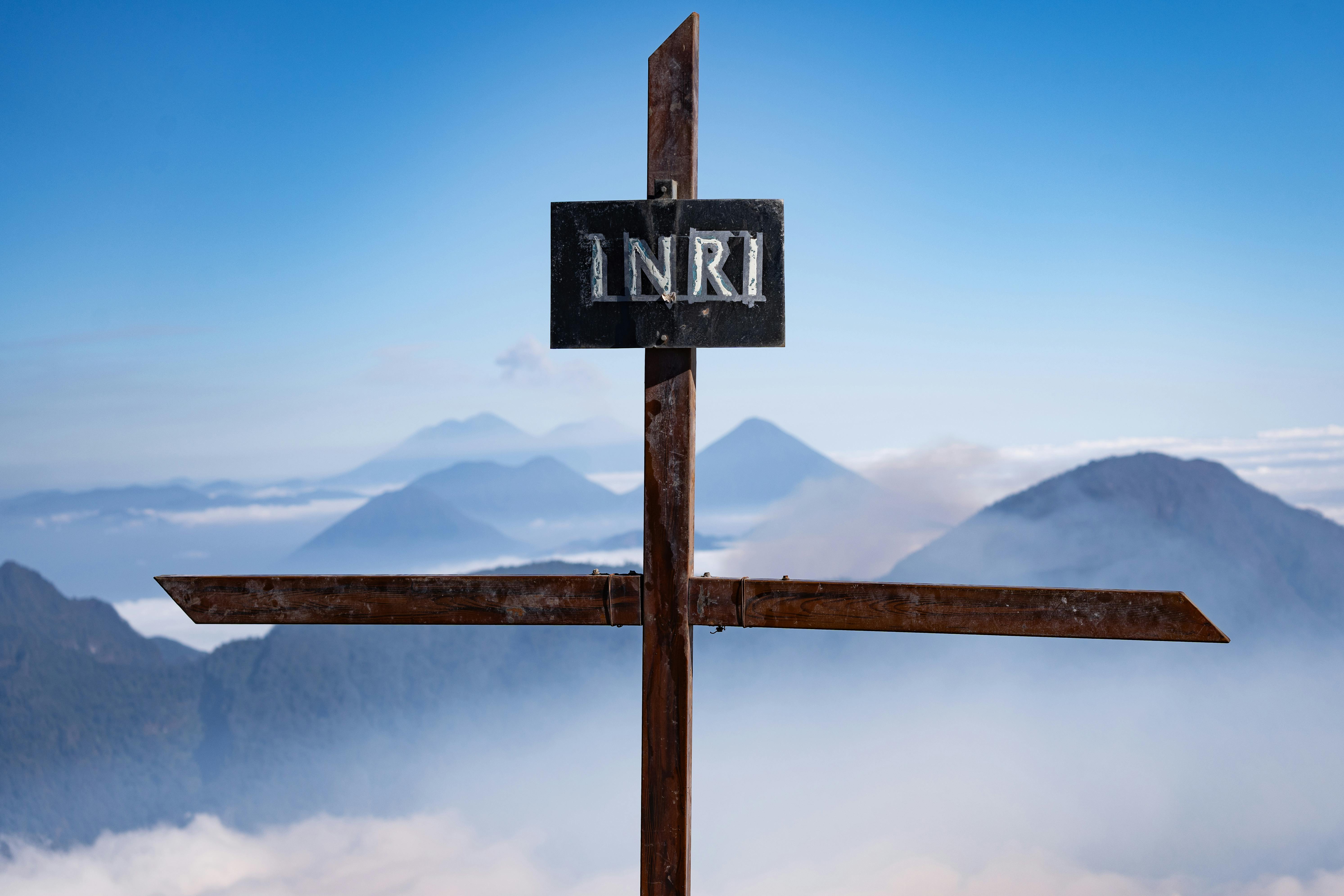 A sign pointing to the word inu with a mountain in the background ...