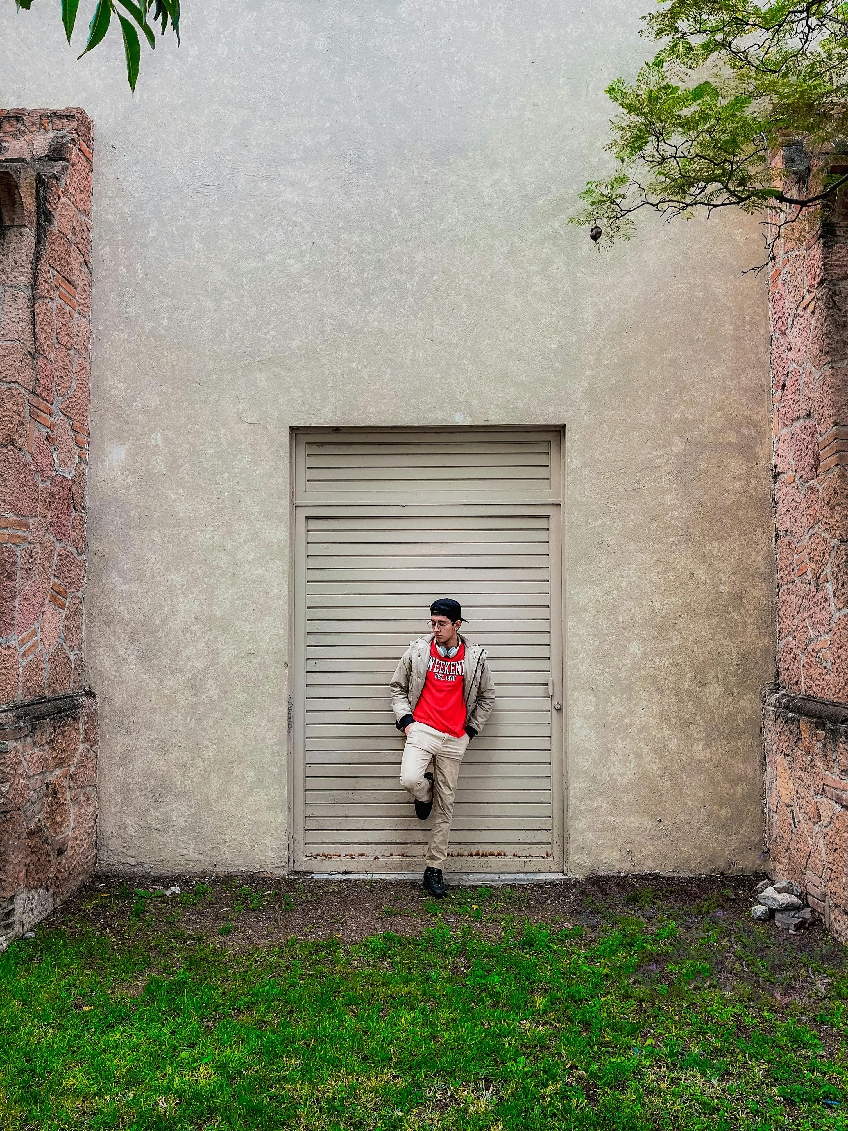 A Teenage Boy Leaning Against Metal Doors · Free Stock Photo