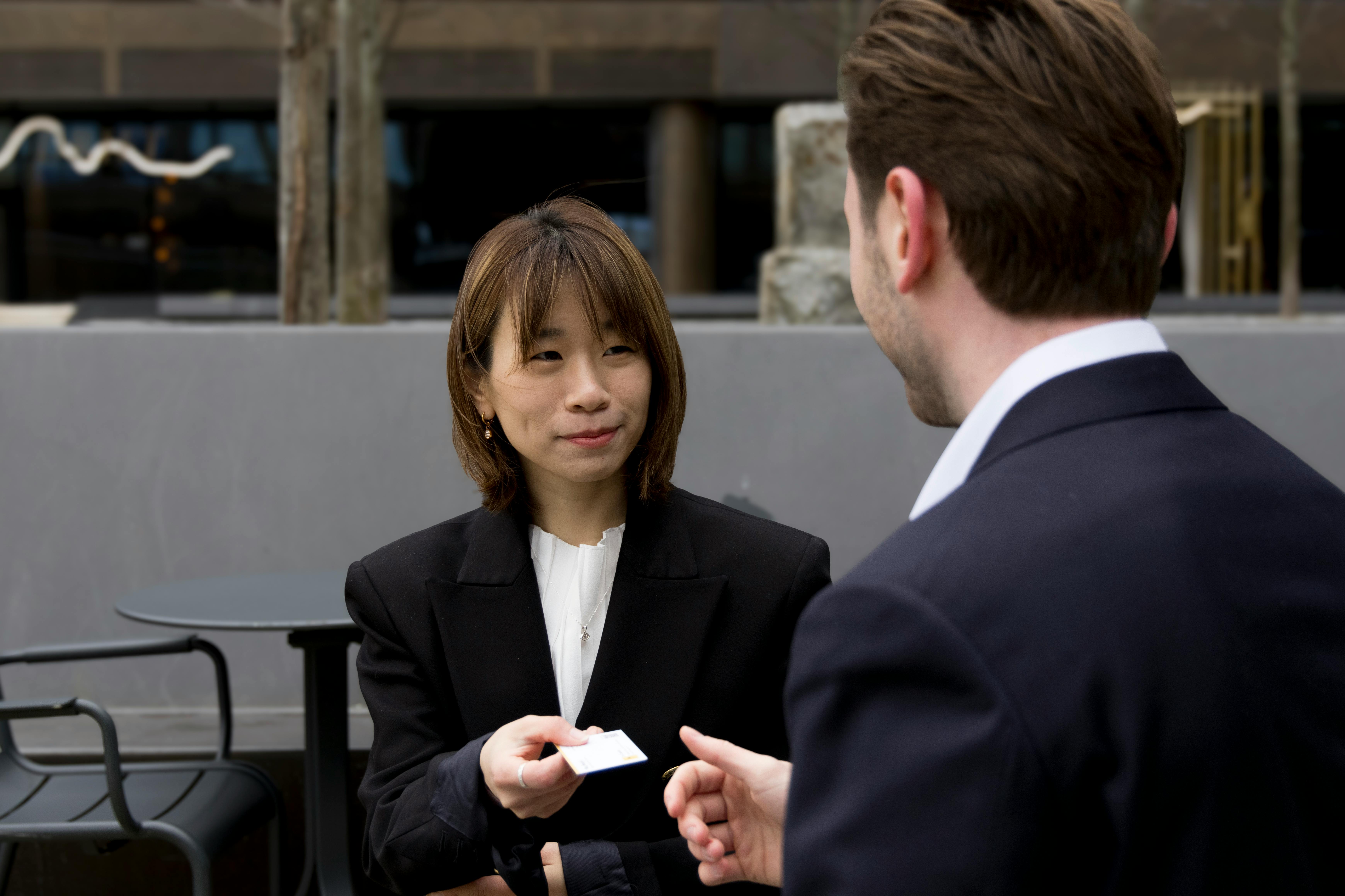 Smiling Businessman and Businesswoman Exchanging a Business Card at a ...