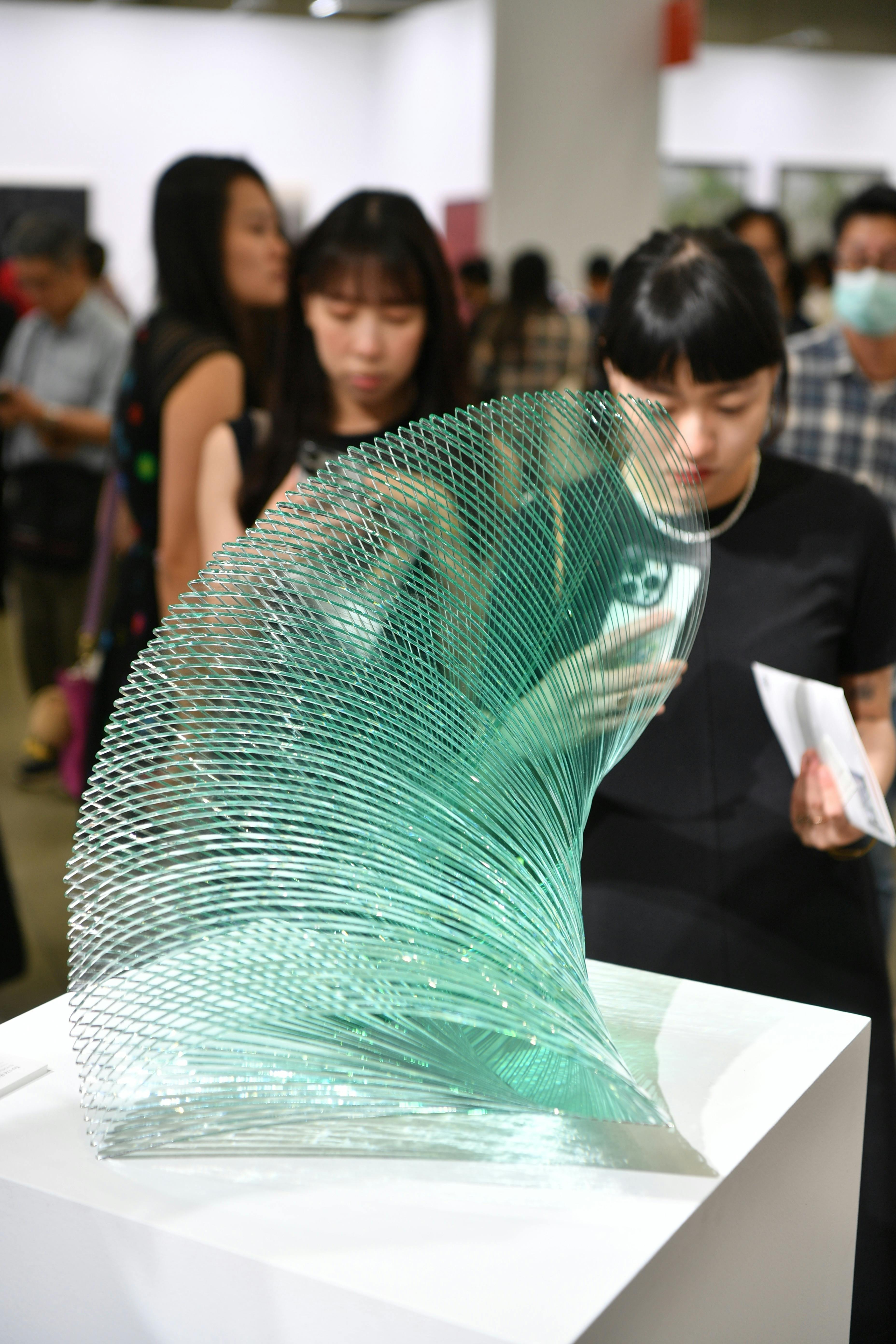 A Woman Photographing an Abstract Glass Sculpture on Display · Free ...