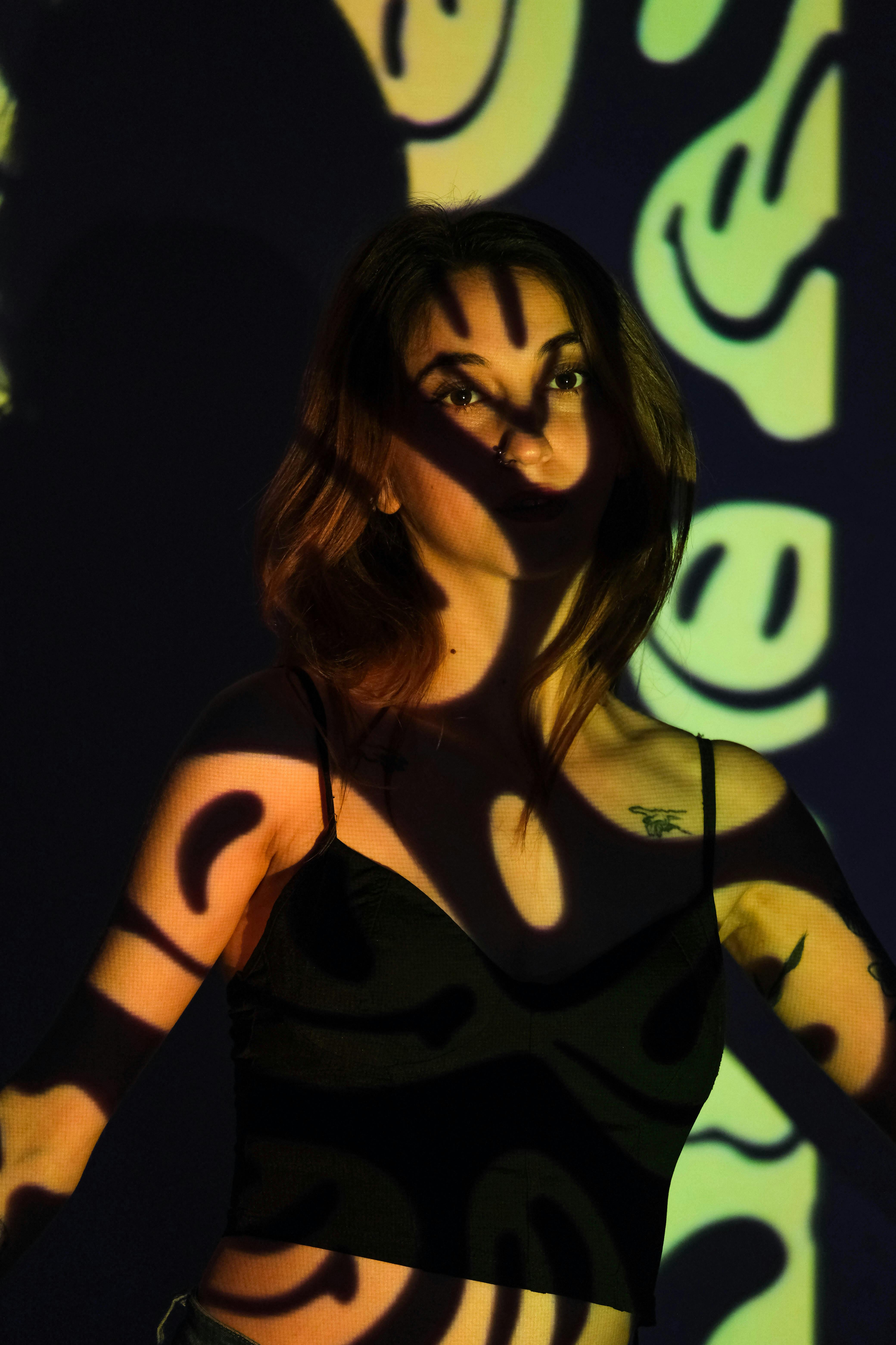 Woman Standing in front of Smiley Faces Projection · Free Stock Photo