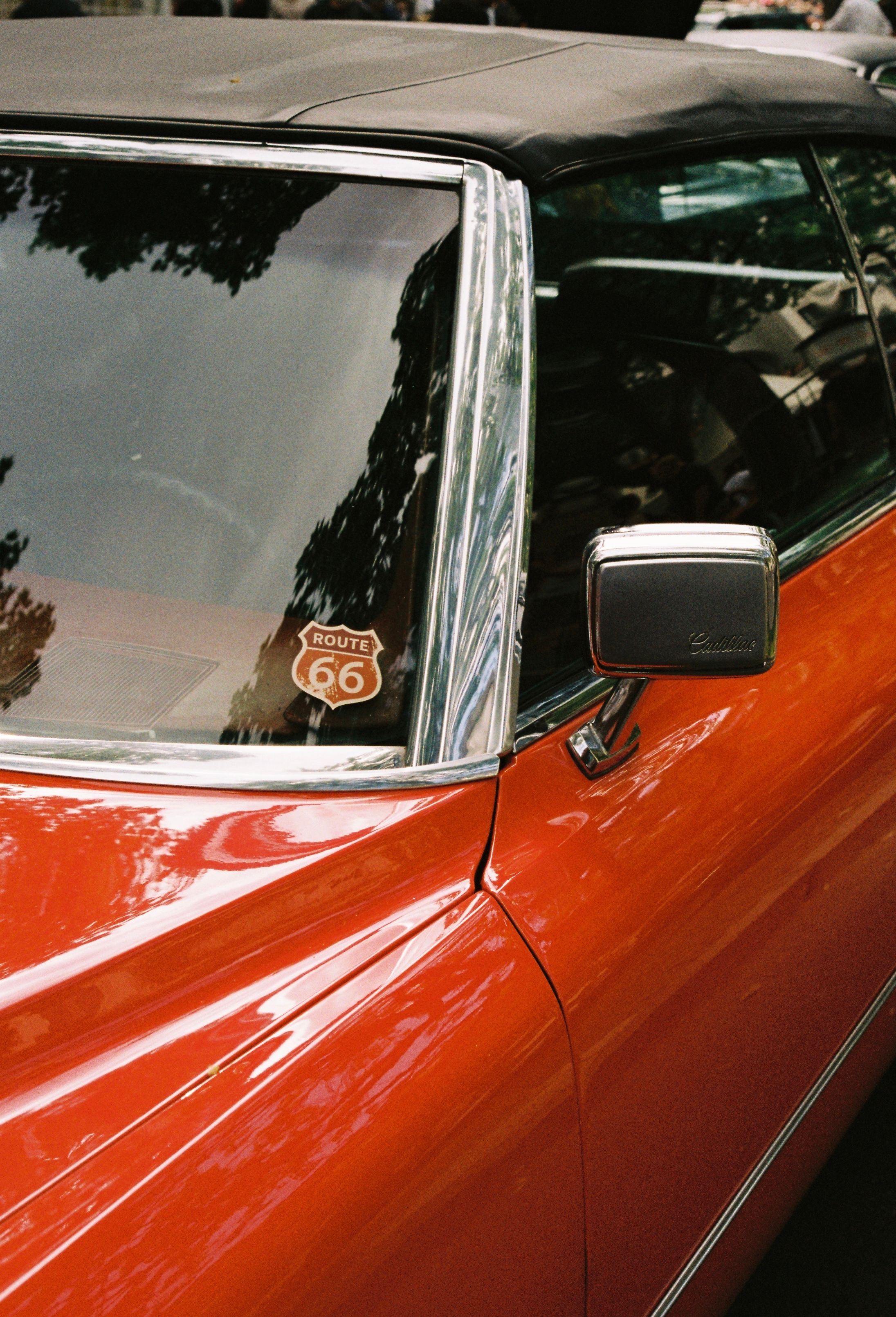 A close up of a red car with a sticker on the side · Free Stock Photo