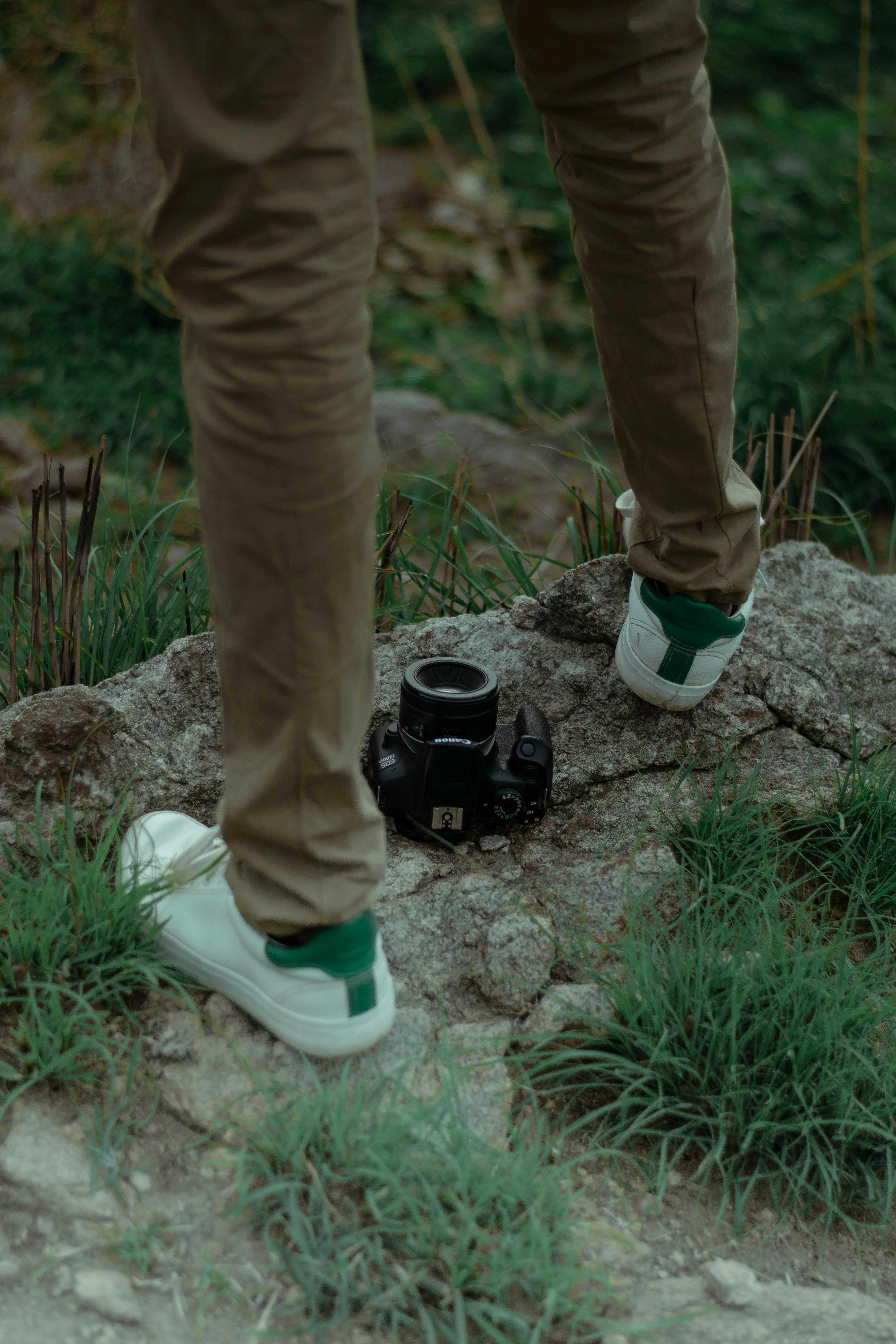 Black Camera and a Person Standing on Rocks · Free Stock Photo