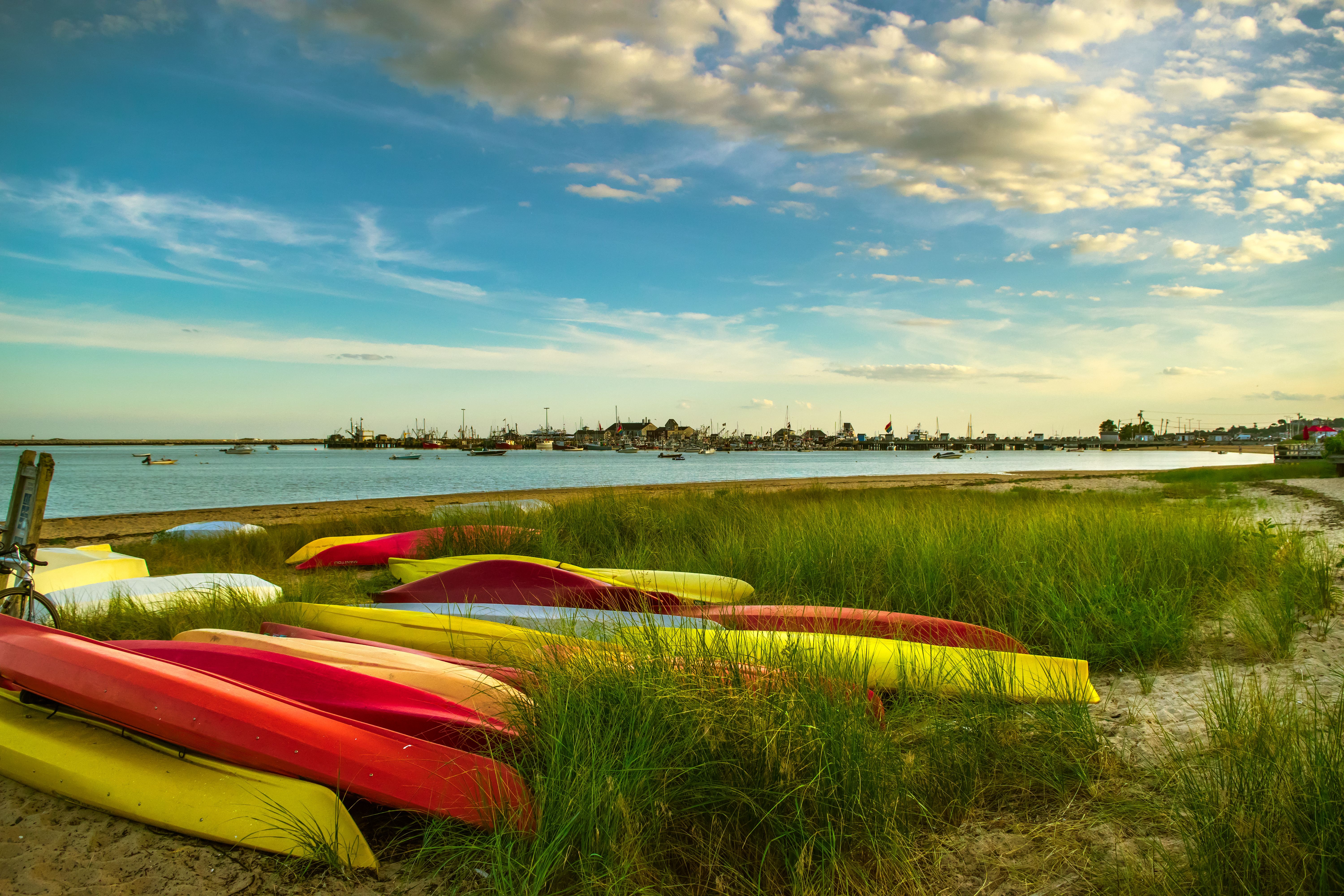 View of Kayaks Lying on the Grass by the Lake · Free Stock Photo