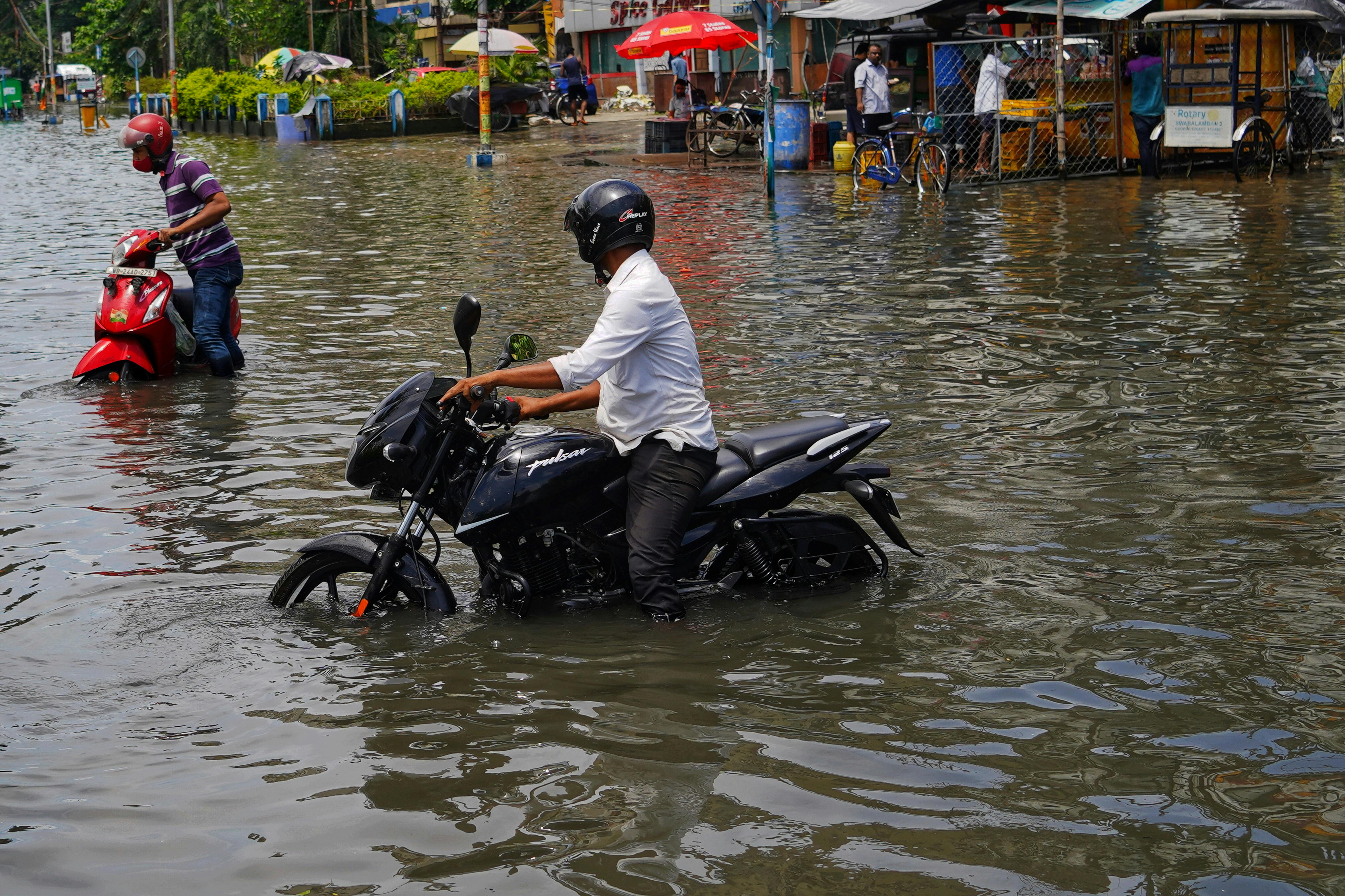 Man Dragging a Motorcycle Through the Flooding · Free Stock Photo