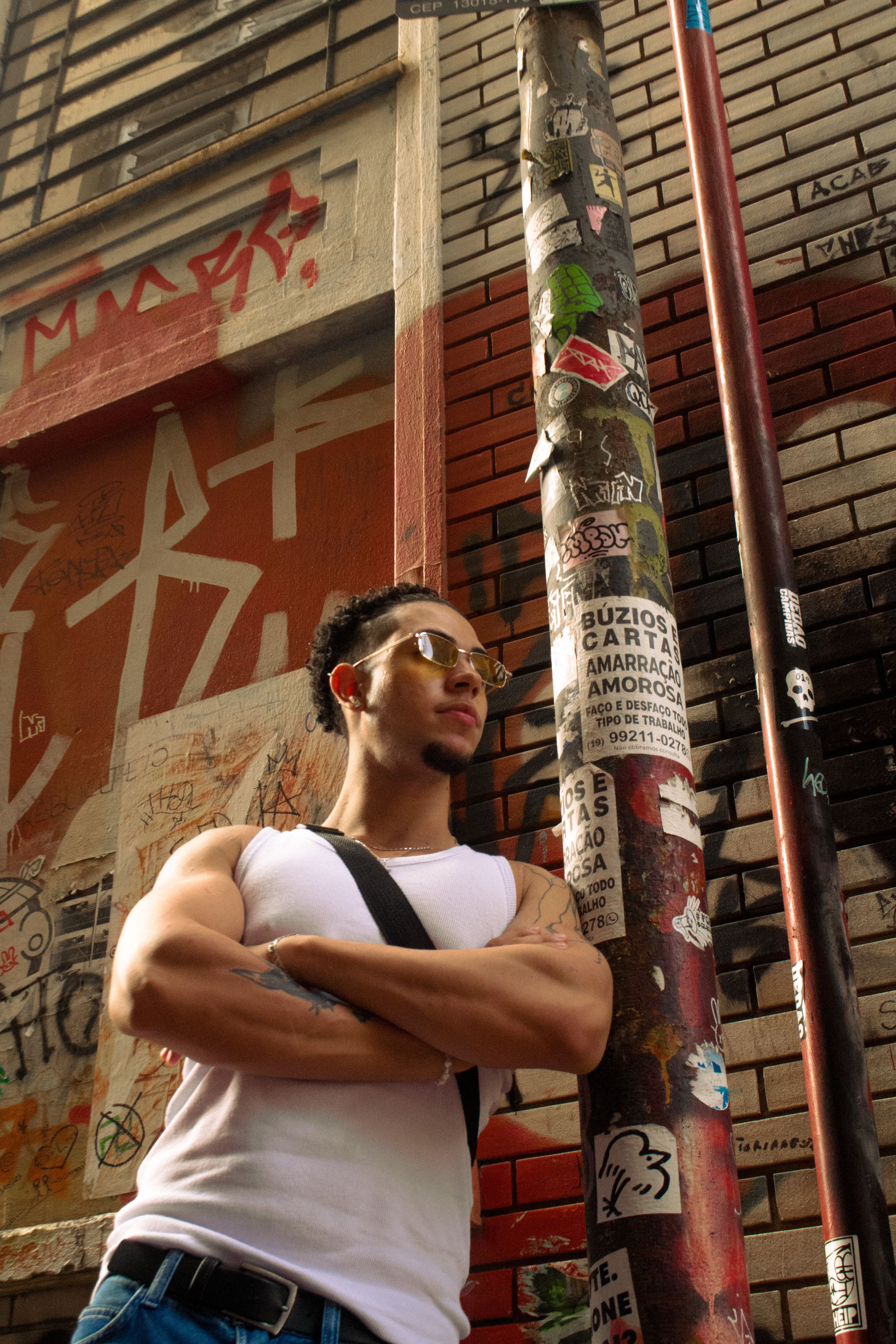 Low Angle Shot of a Young Man Leaning against a Pole with Stickers ...