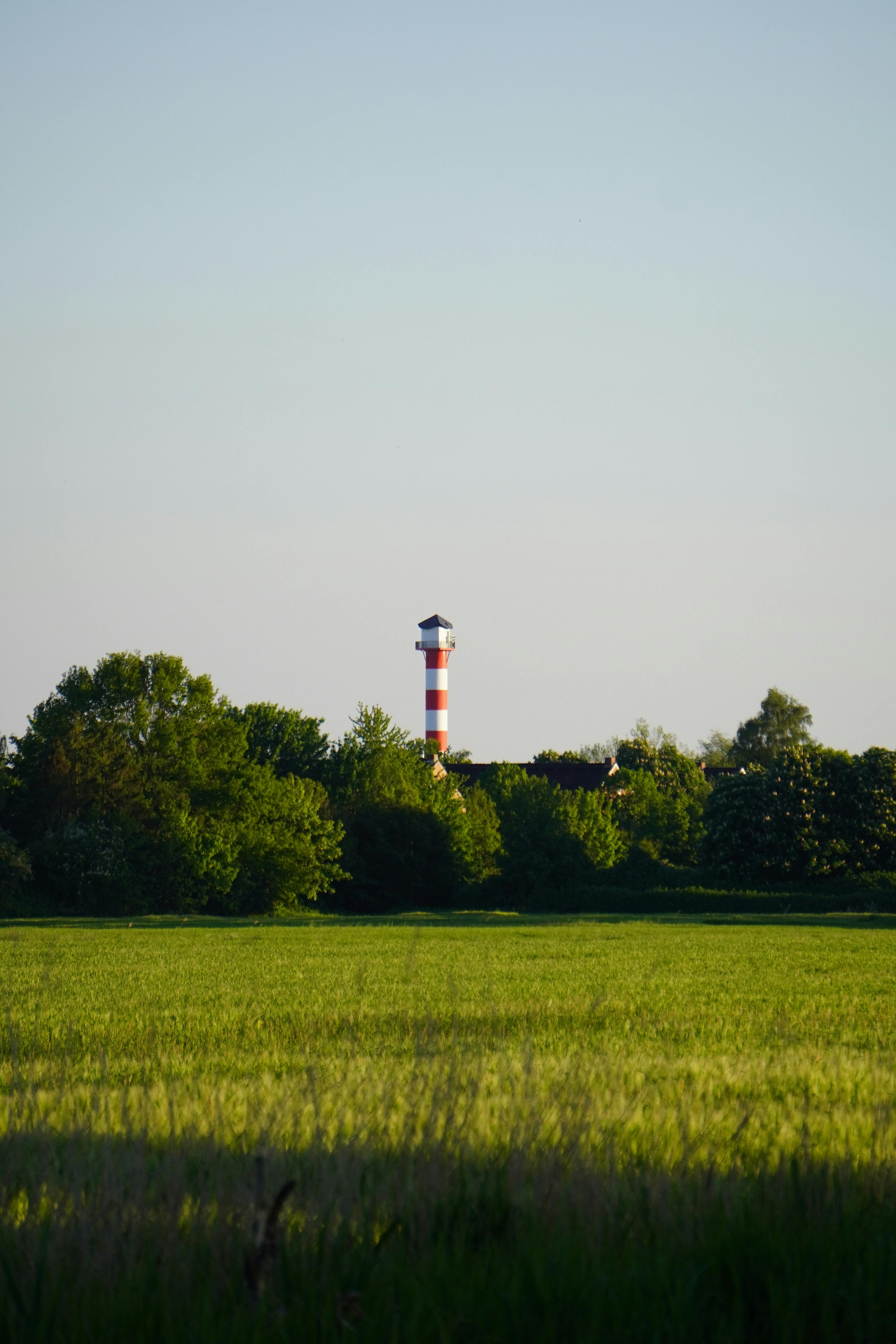 A tall lighthouse in the middle of a field · Free Stock Photo