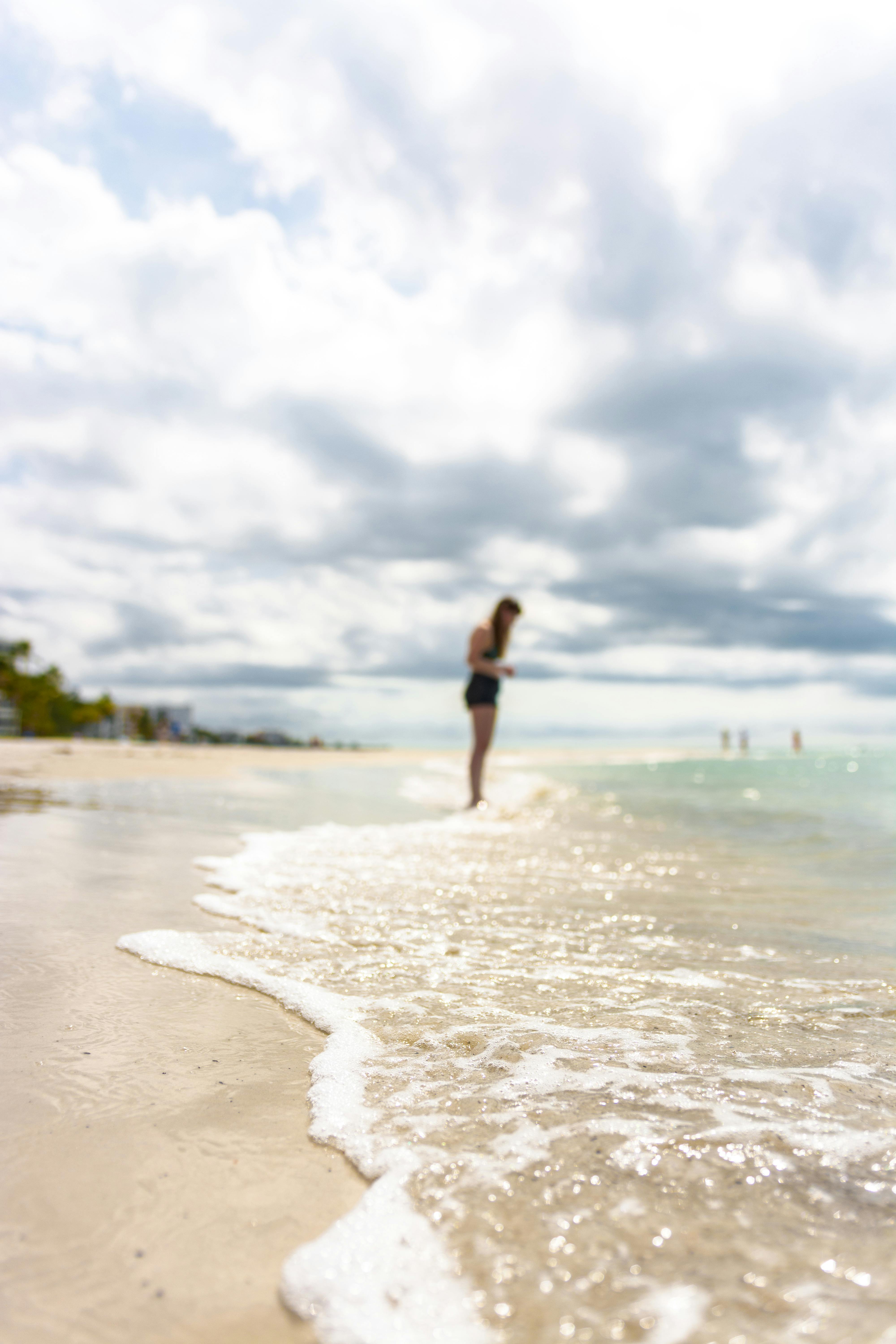 Low Angle View of Woman Relaxing on Beach Against Blue Sky · Free Stock ...