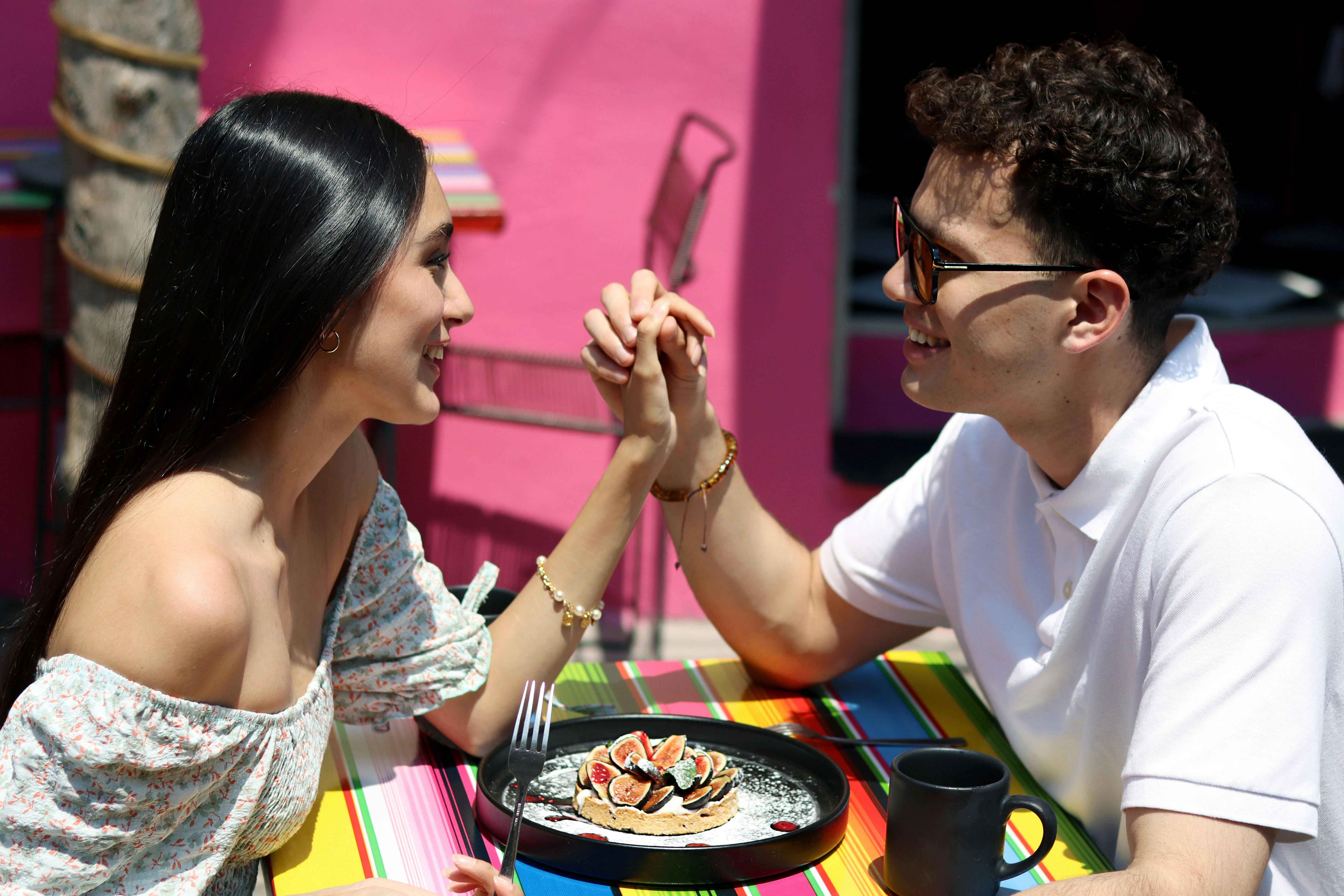 Woman and a Man Holding Hands over the Table · Free Stock Photo