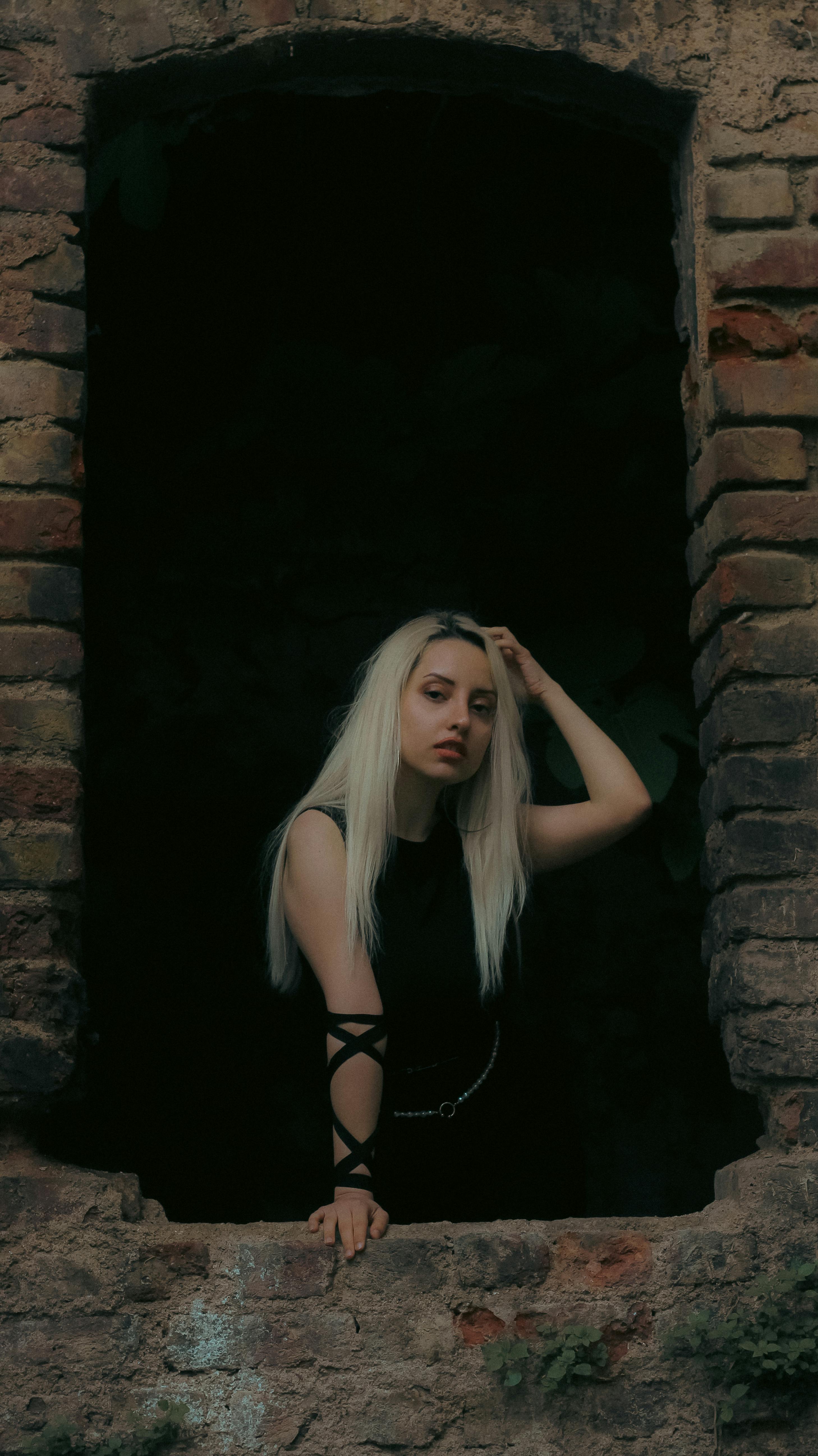 Blonde Woman Standing in Window Opening · Free Stock Photo