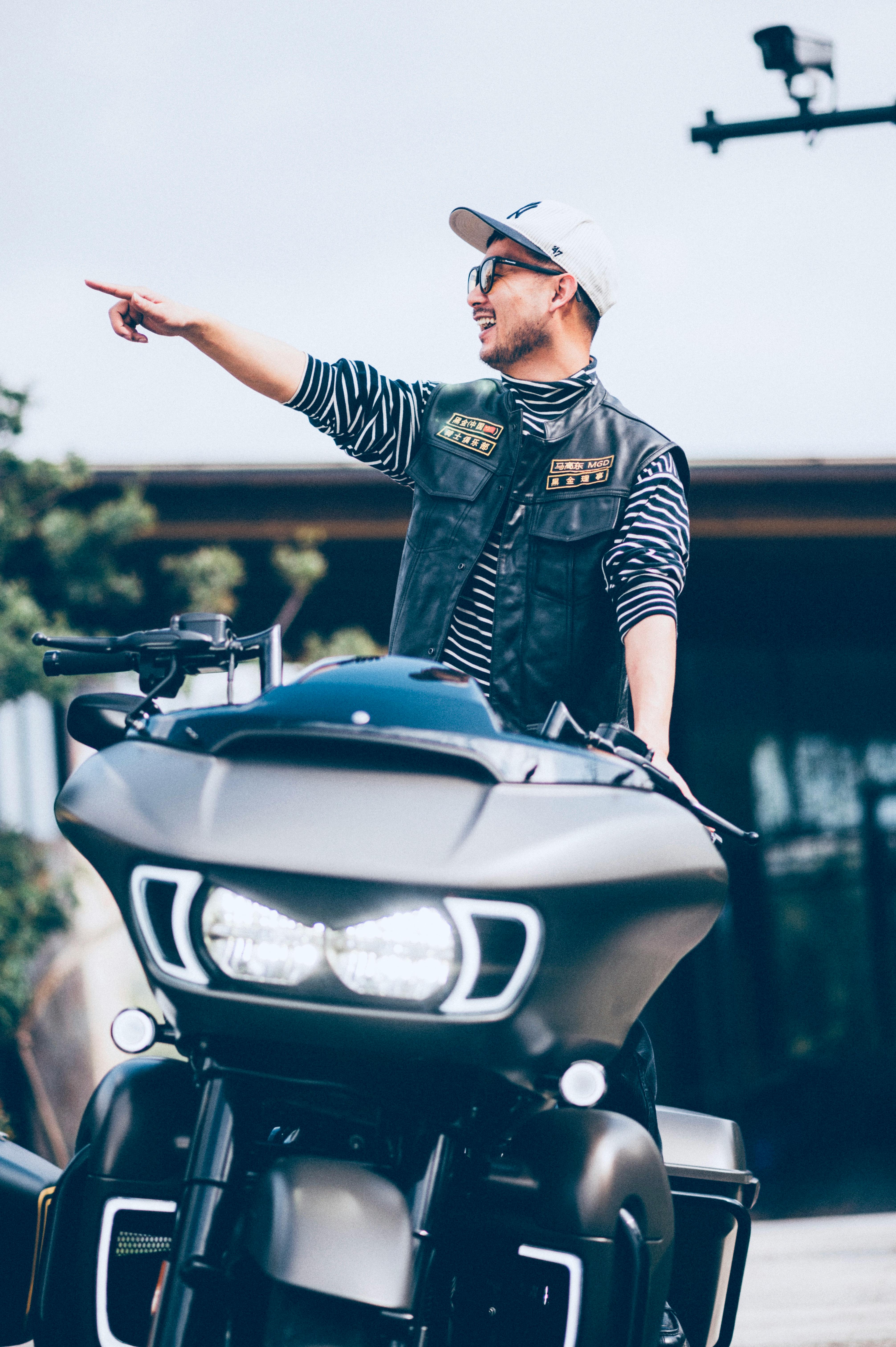 Man Pointing While Riding on a Black Harley Davidson · Free Stock Photo