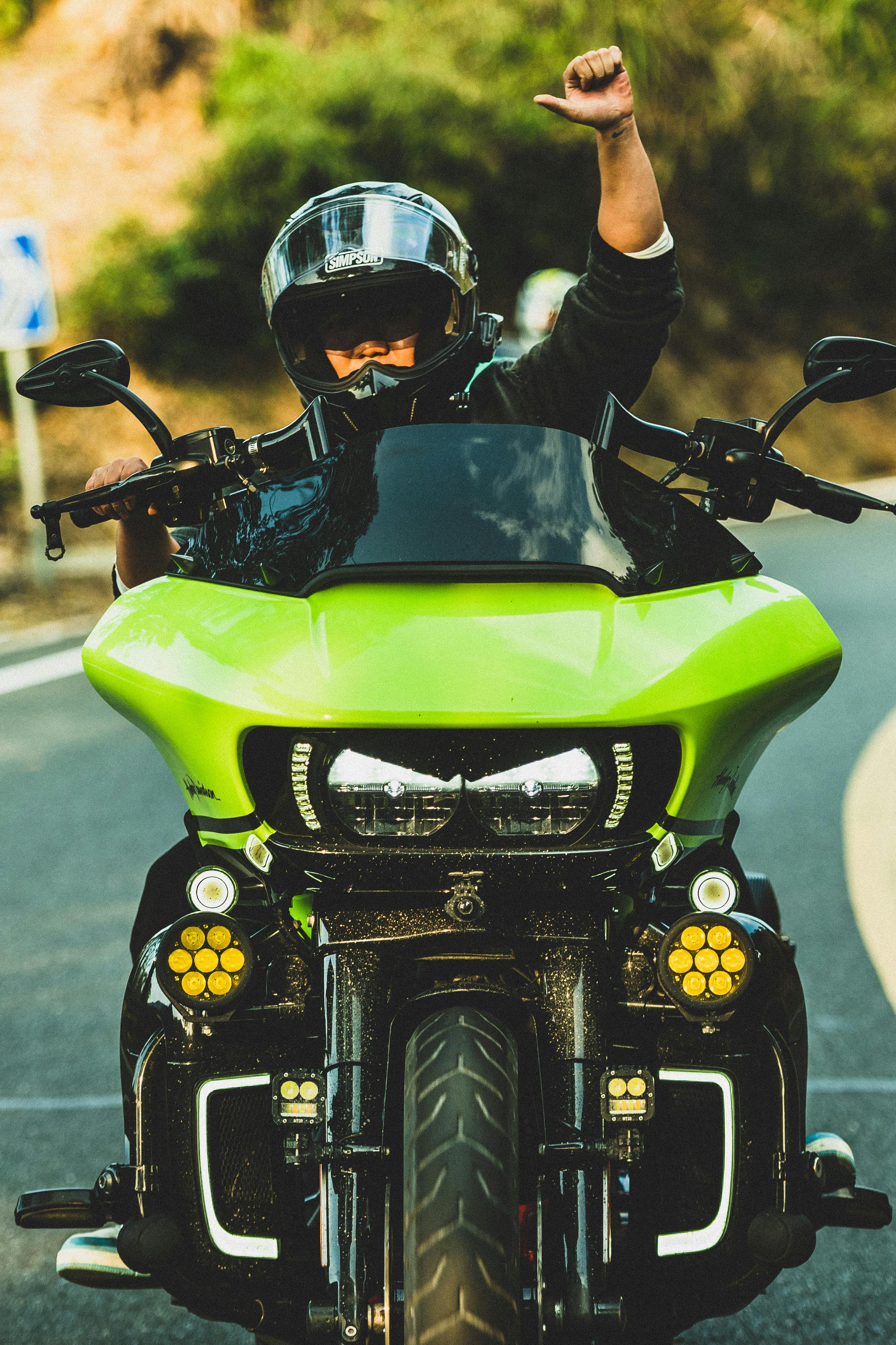 Man in Helmet with Raised Arm on Motorbike · Free Stock Photo