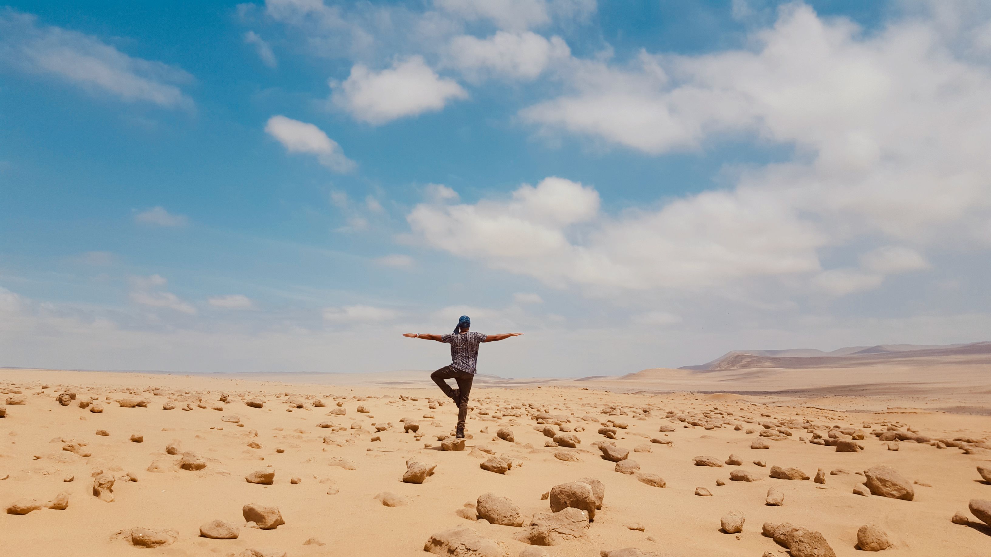A man standing on one leg with arms wide in a desert, Peru · Free Stock ...