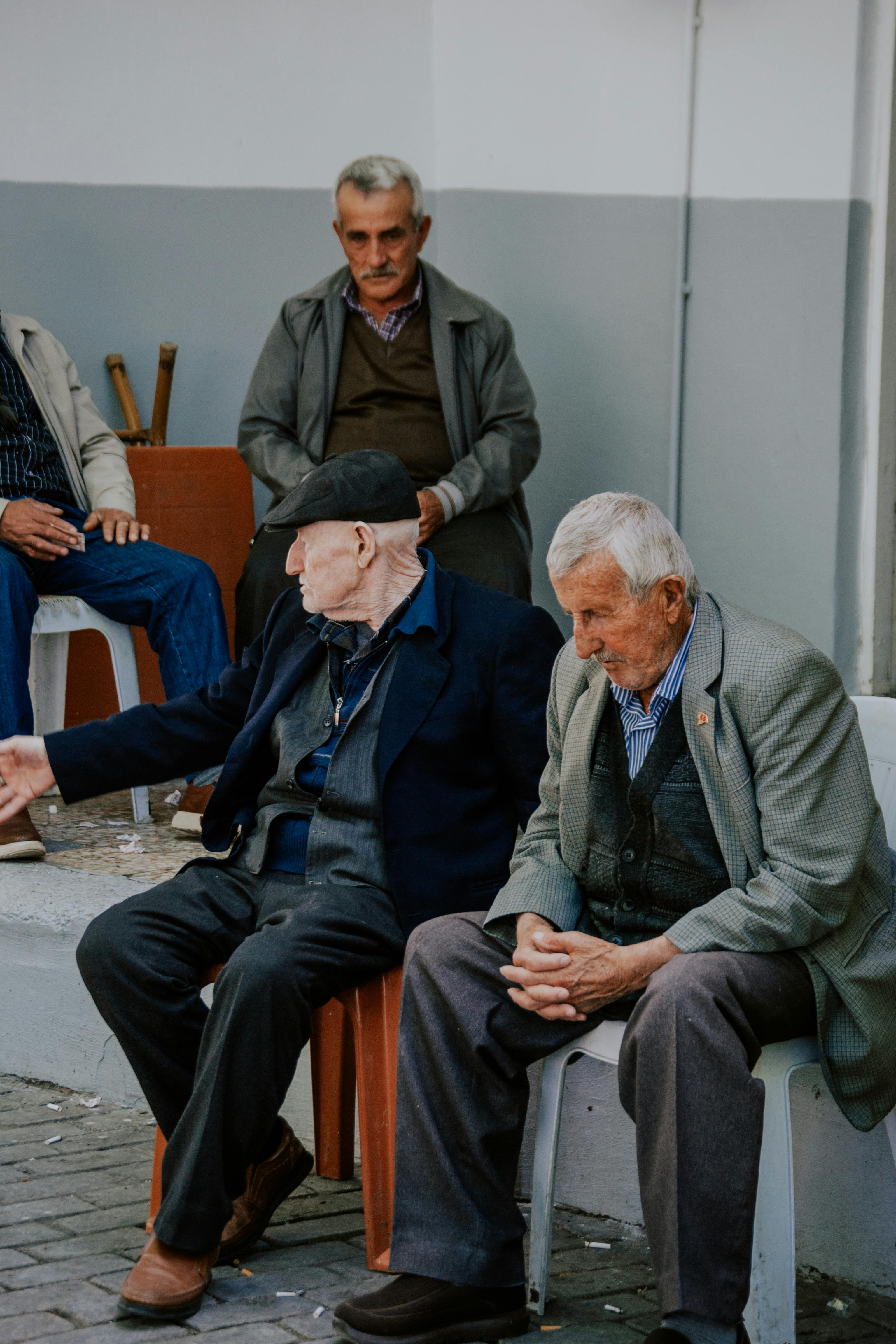 Three older men sitting on a bench together · Free Stock Photo