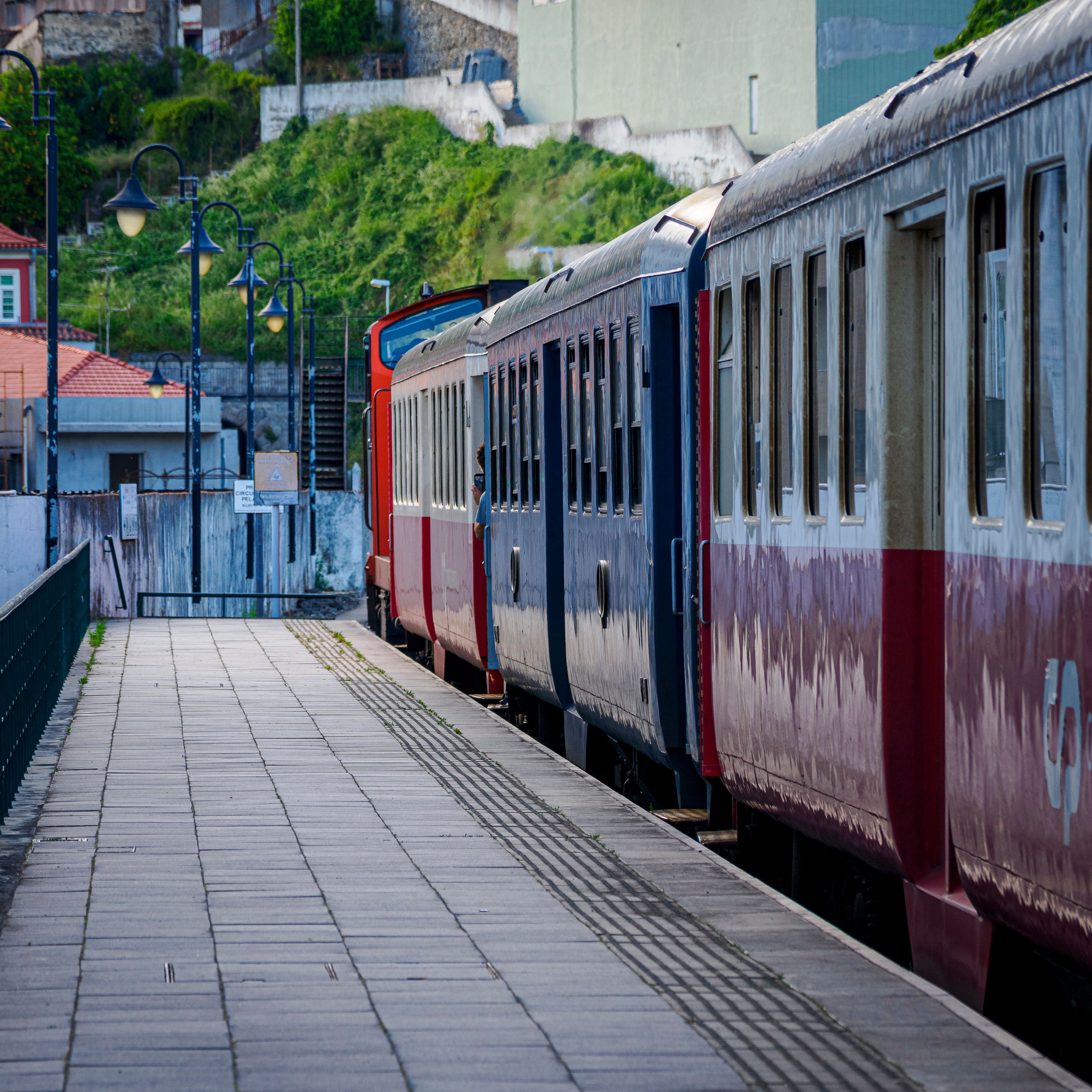 A train is parked on the tracks next to a building · Free Stock Photo