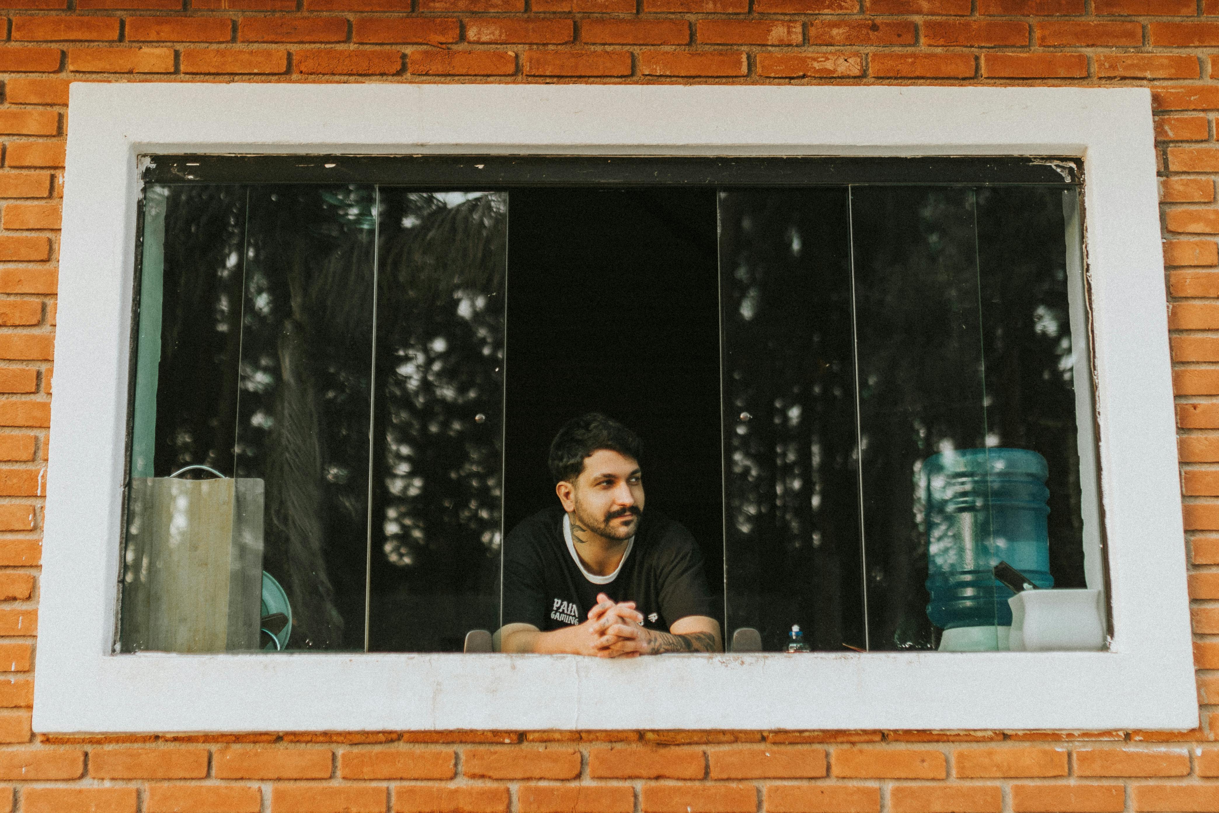 Man Standing Out Window · Free Stock Photo