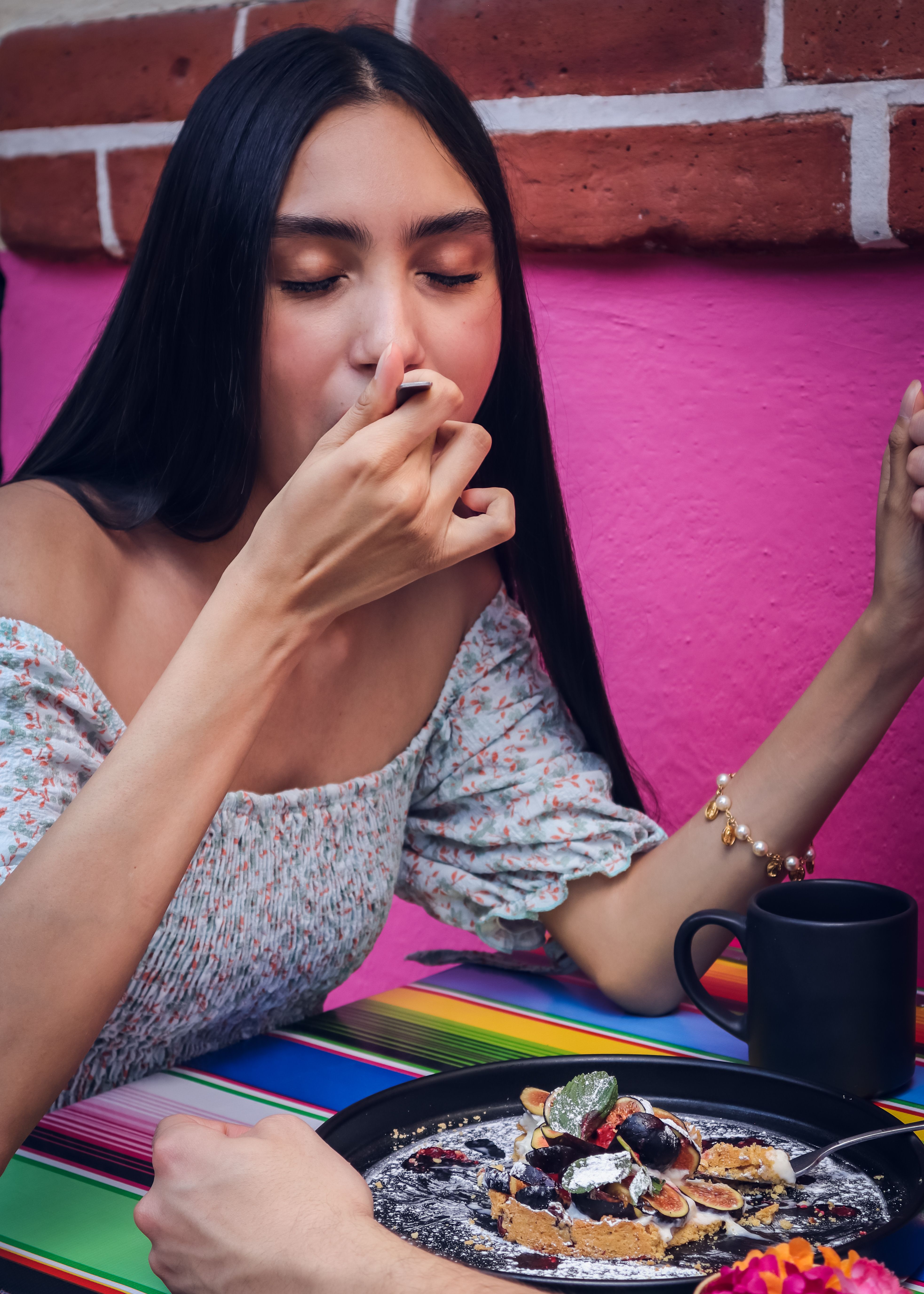 A woman eating a plate of food with her hands · Free Stock Photo