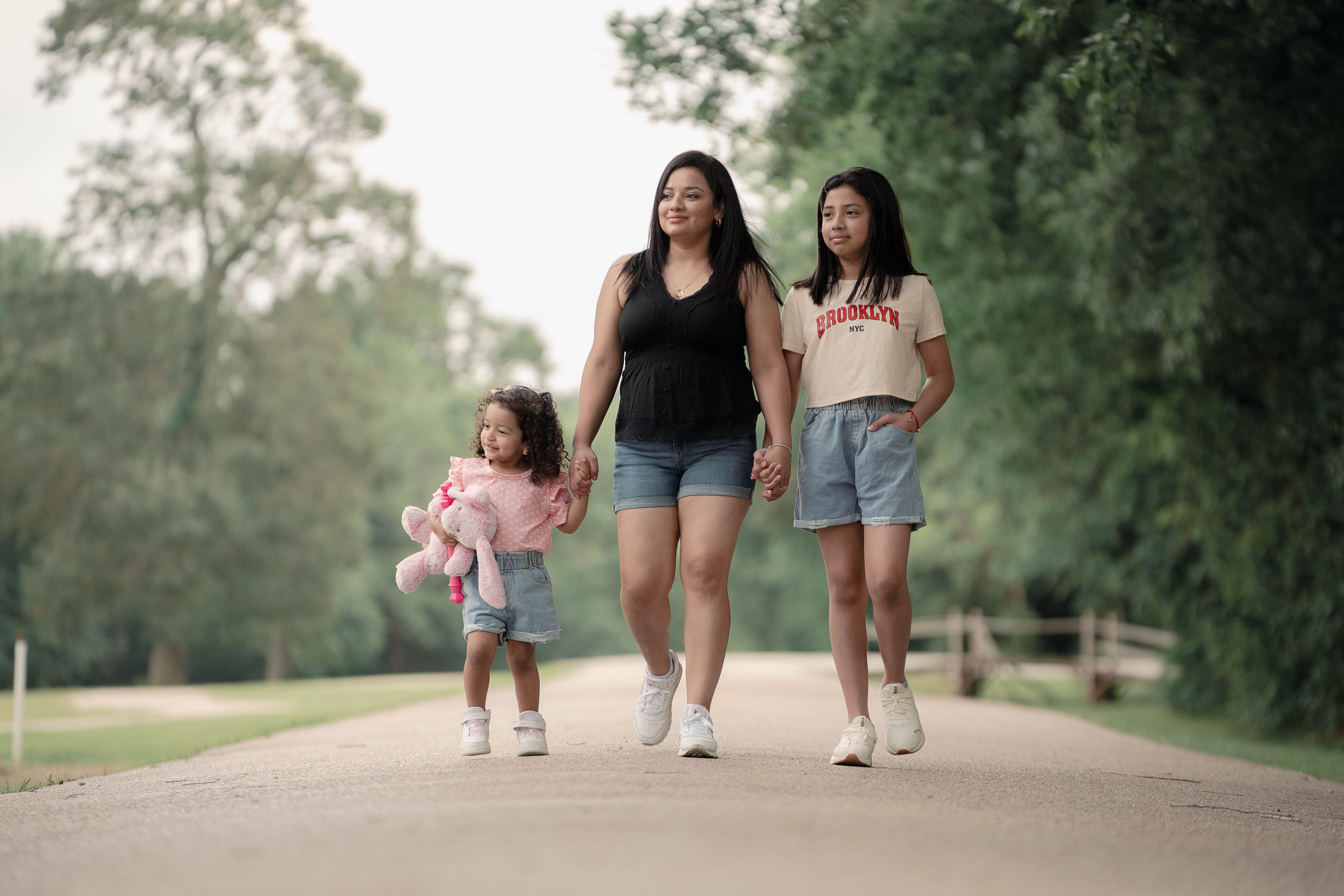 Two women and a girl walking down a path · Free Stock Photo