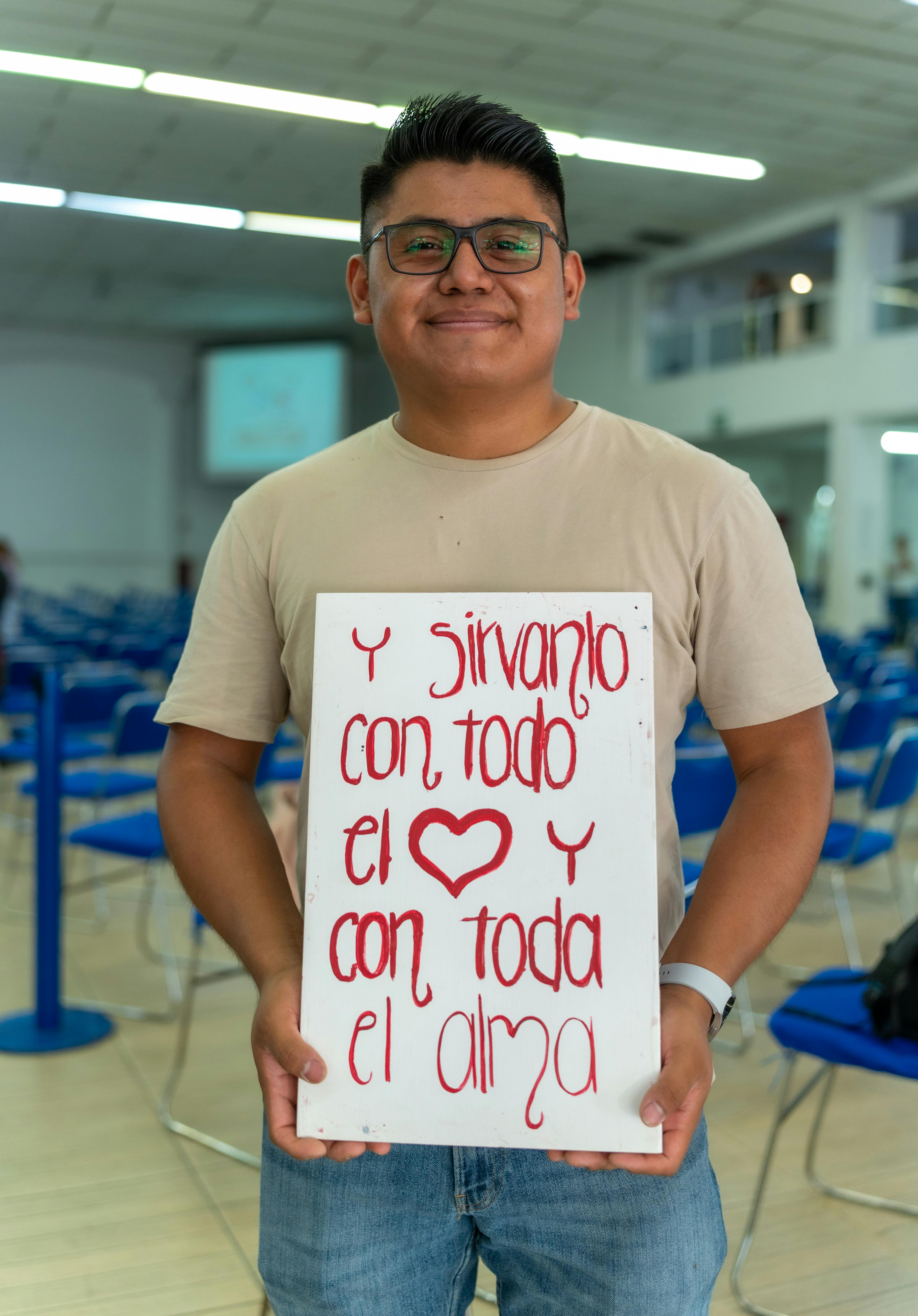 Man Standing with a Paper Sheet and Text Written on it · Free Stock Photo