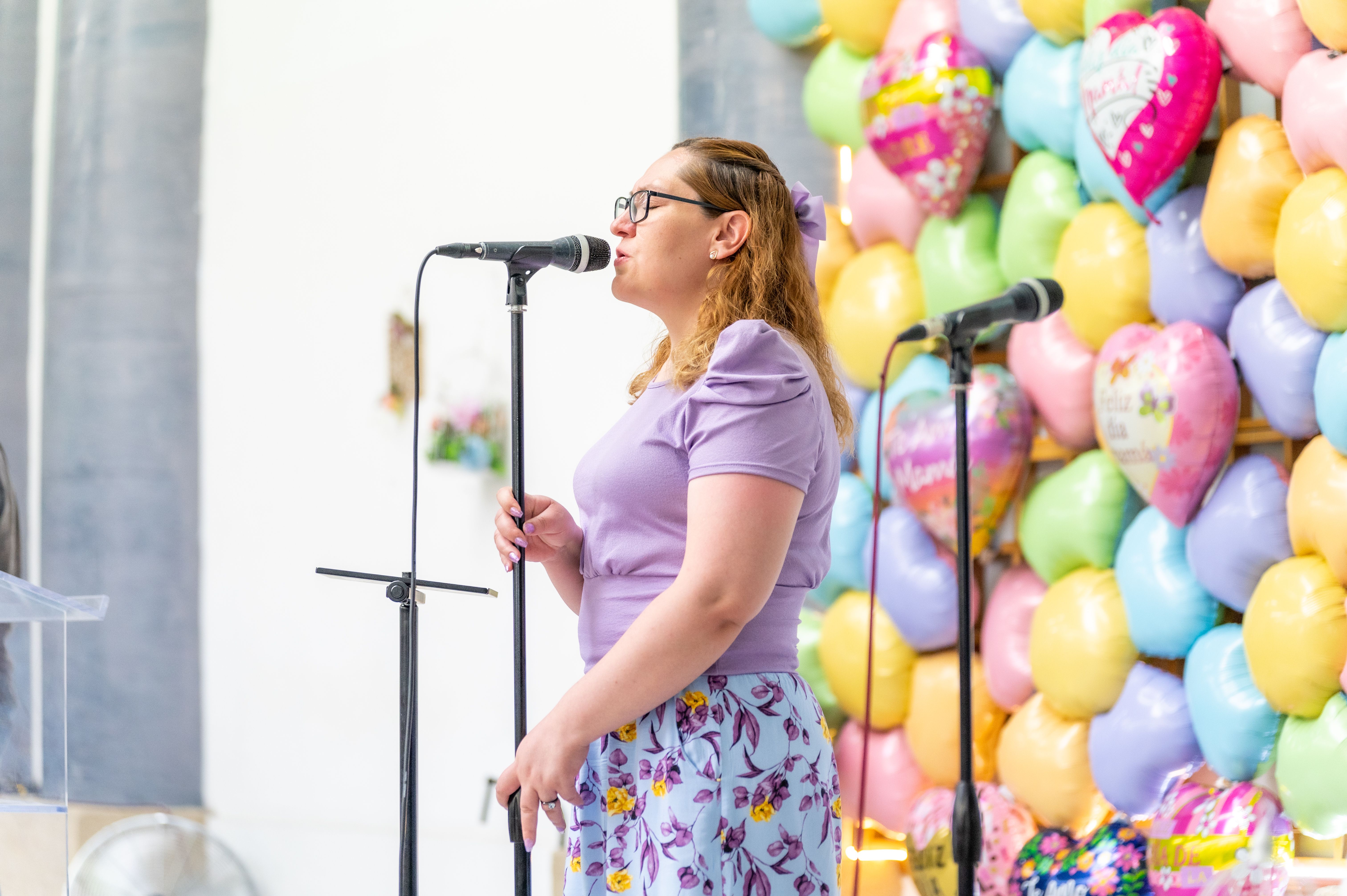 Side View of a Woman Singing on a Stage with Colorful Decorations ...