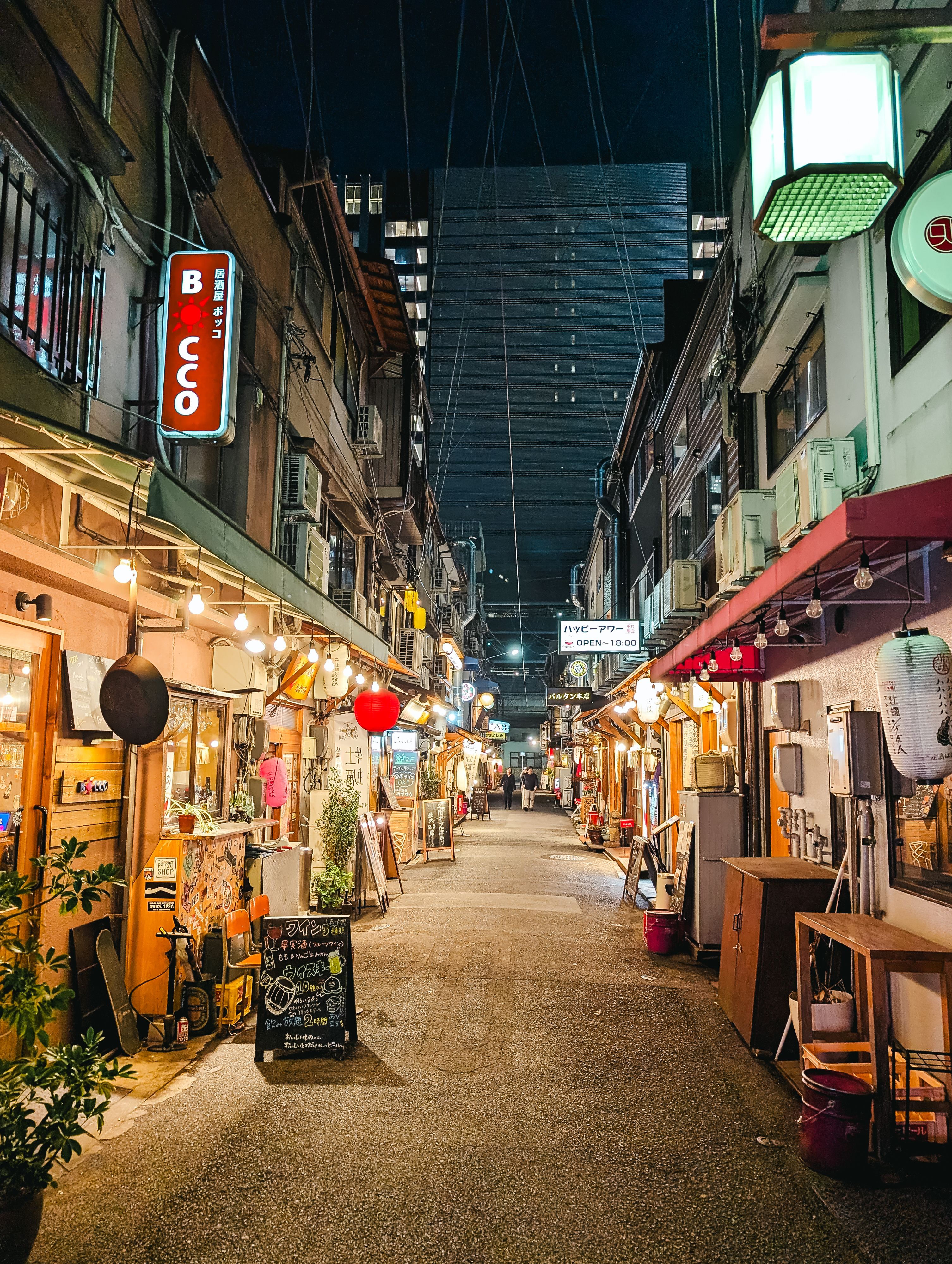 A street with many shops and restaurants at night · Free Stock Photo