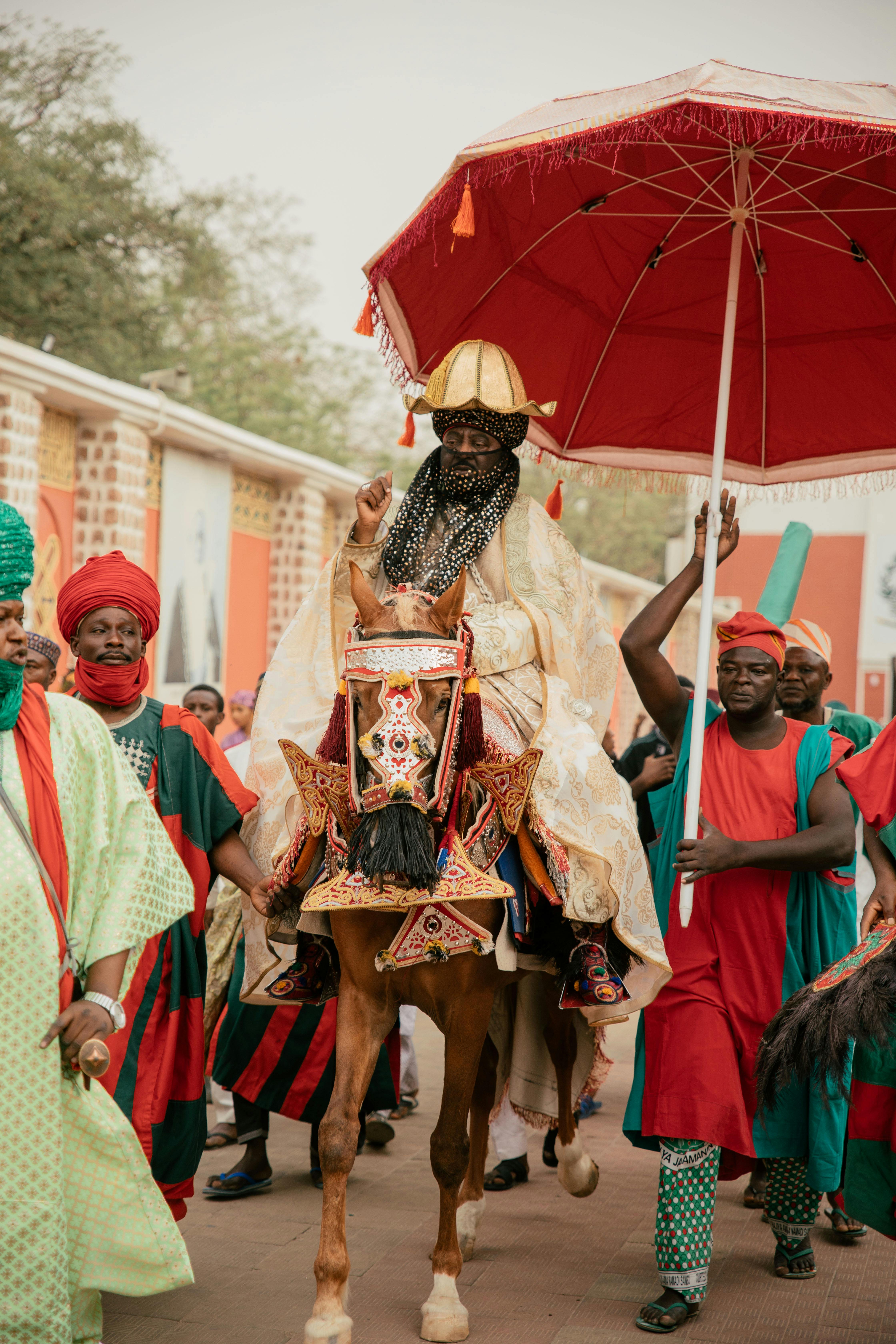 A man in traditional clothing riding a horse with an umbrella · Free ...